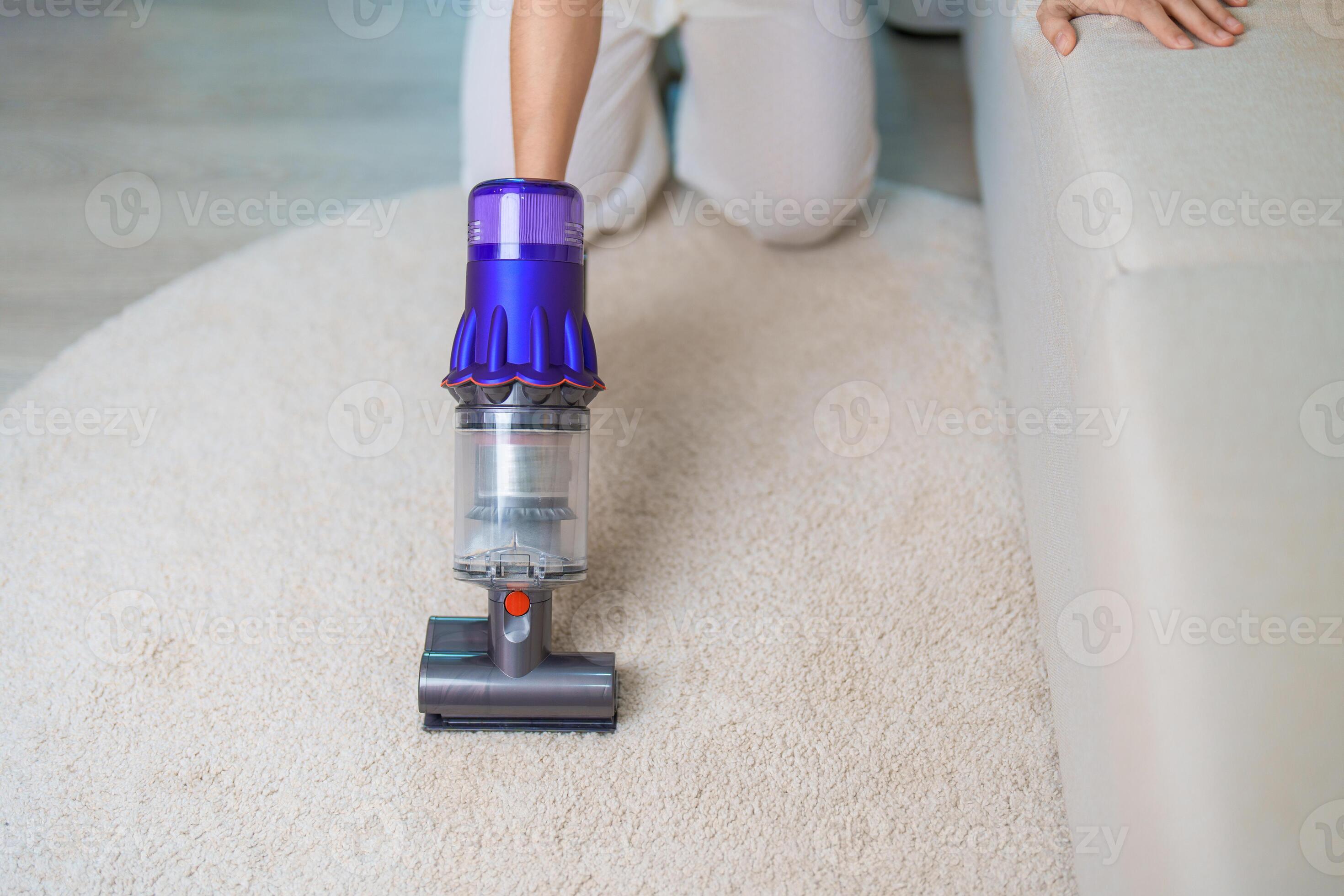 Woman cleaning Carpet with cordless Vacuum cleaner. Housewife using ...
