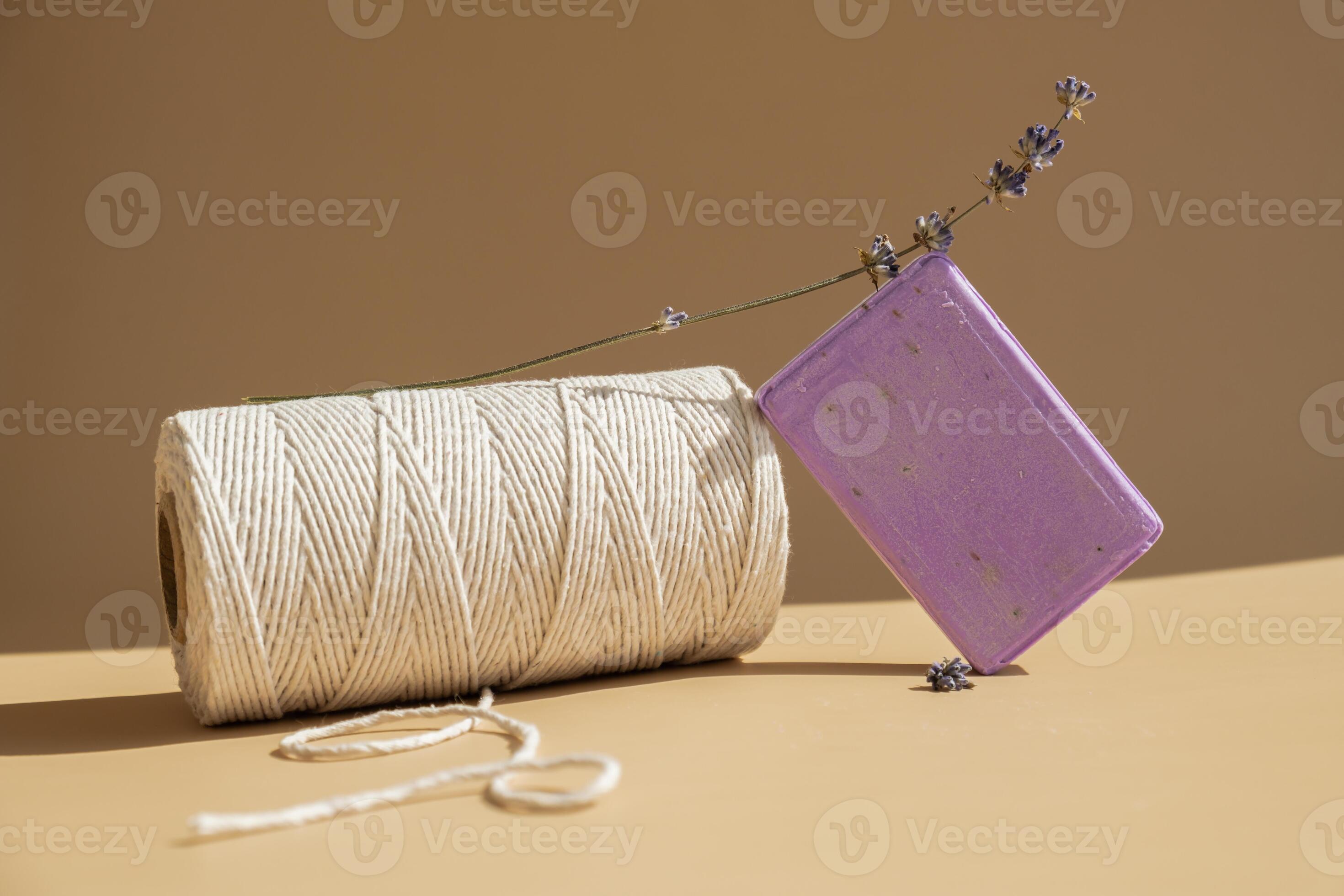 Handcrafted purple lavender soap with lavender flowers and spool of white cotton rope. Natural ...