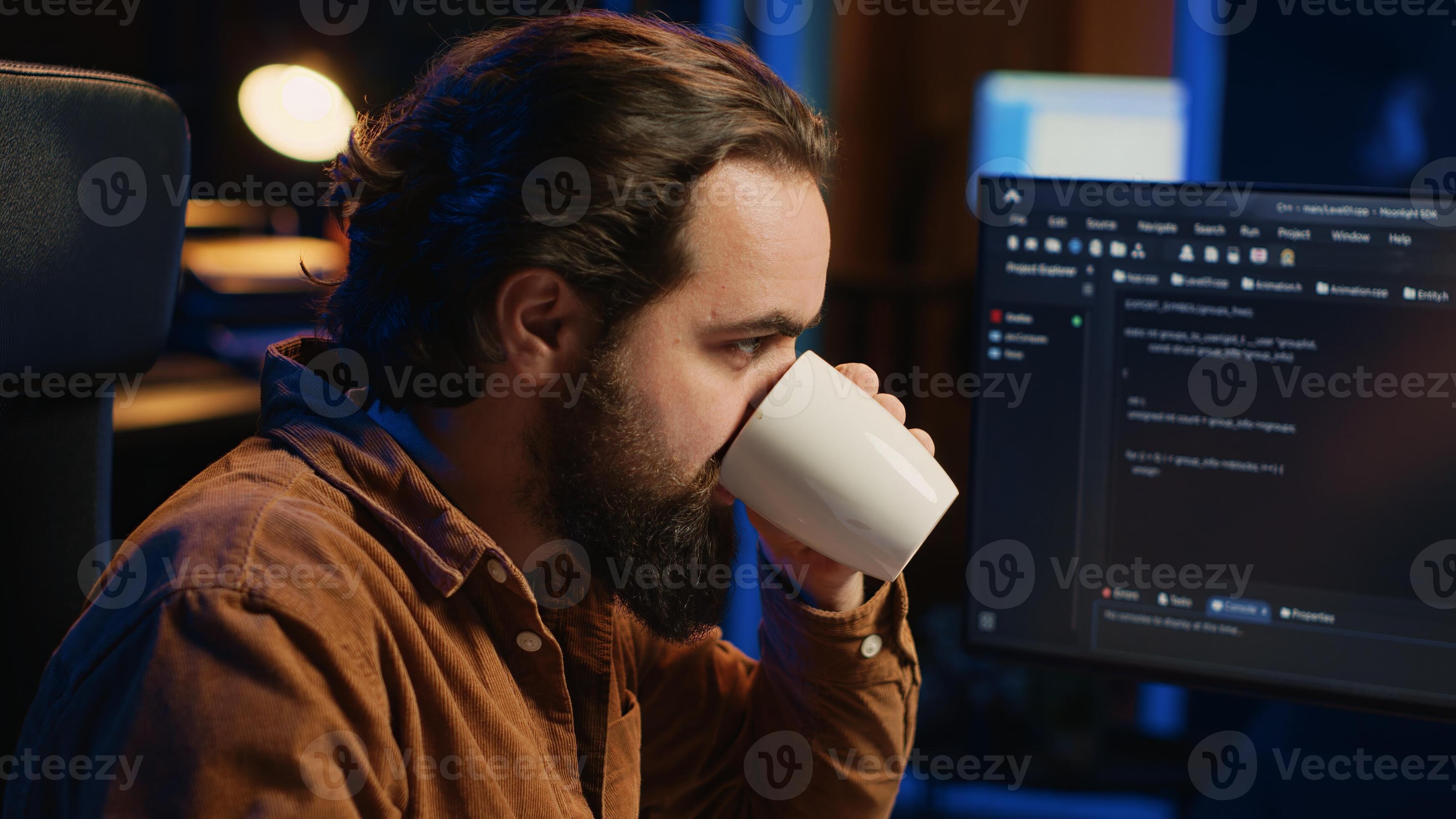 Focused Programmer Drinking Coffee In Apartment While Solving Database Errors On Computer
