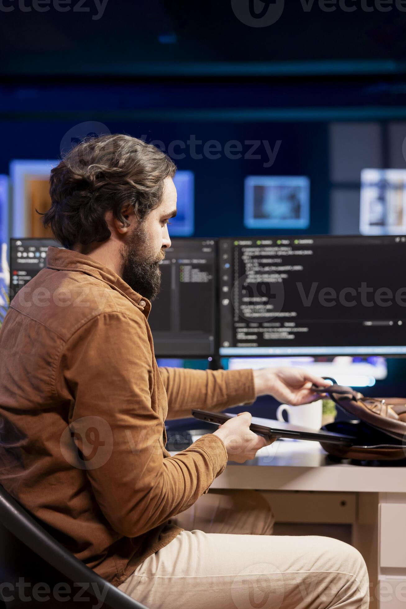 Man packing laptop after finishing doing software quality assurance and reading source code ...