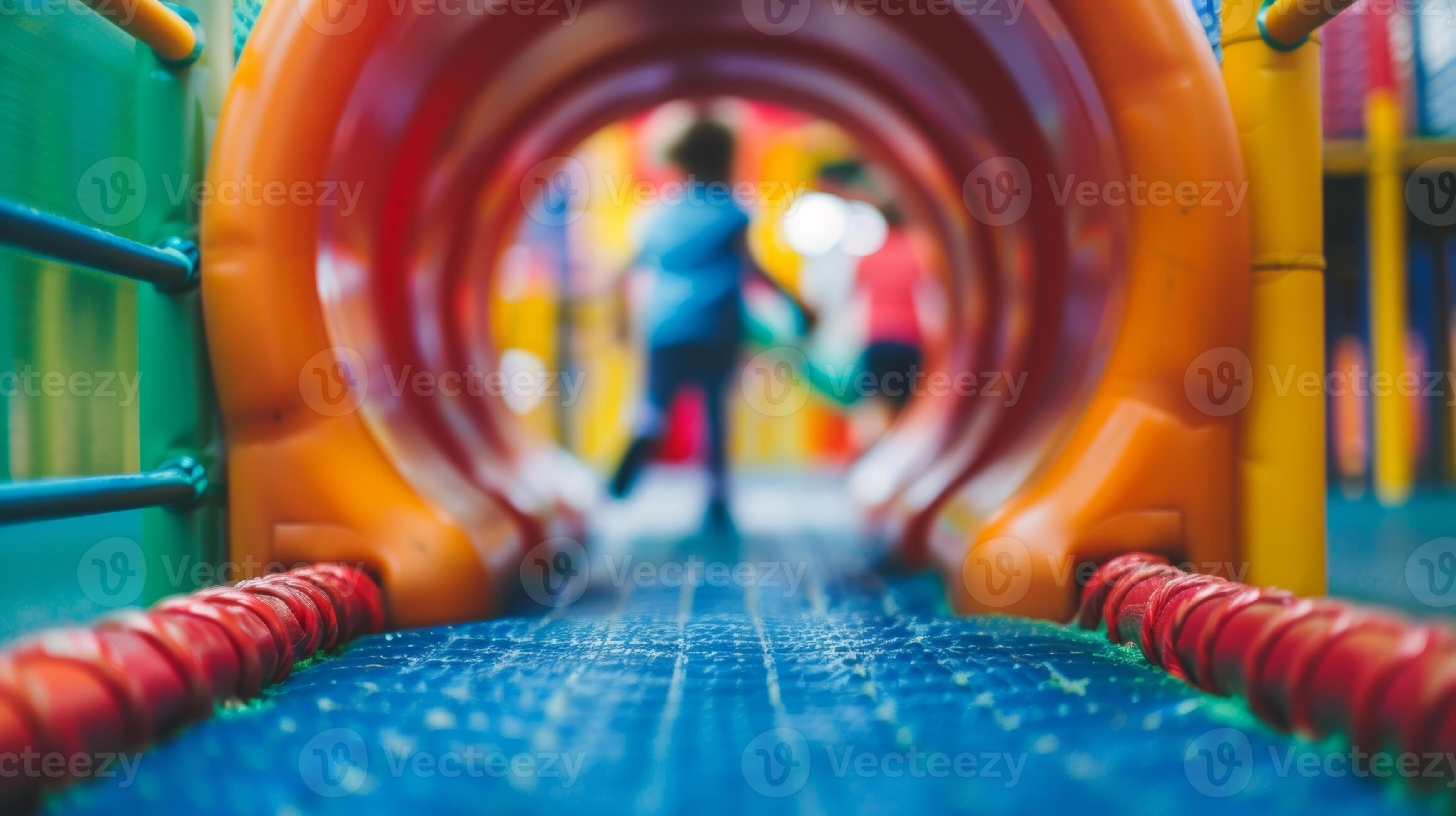 Defocused view of kids navigating a maze of obstacles and tunnels in an ... Defocused view of kids navigating a maze of obstacles and tunnels in an ...