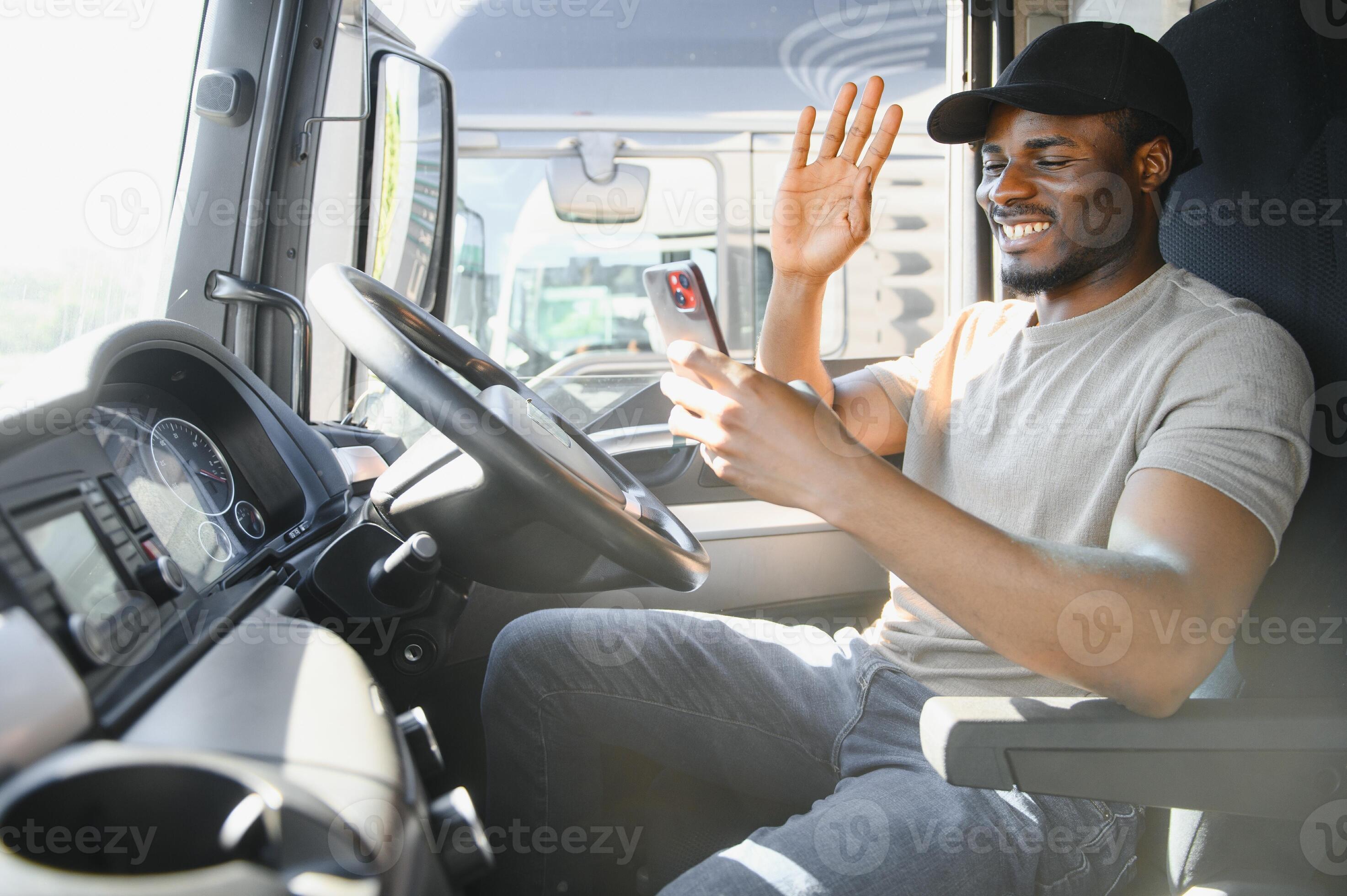 Young african american truck driver using mobile phone while driving ... Young african american truck driver using mobile phone while driving ...
