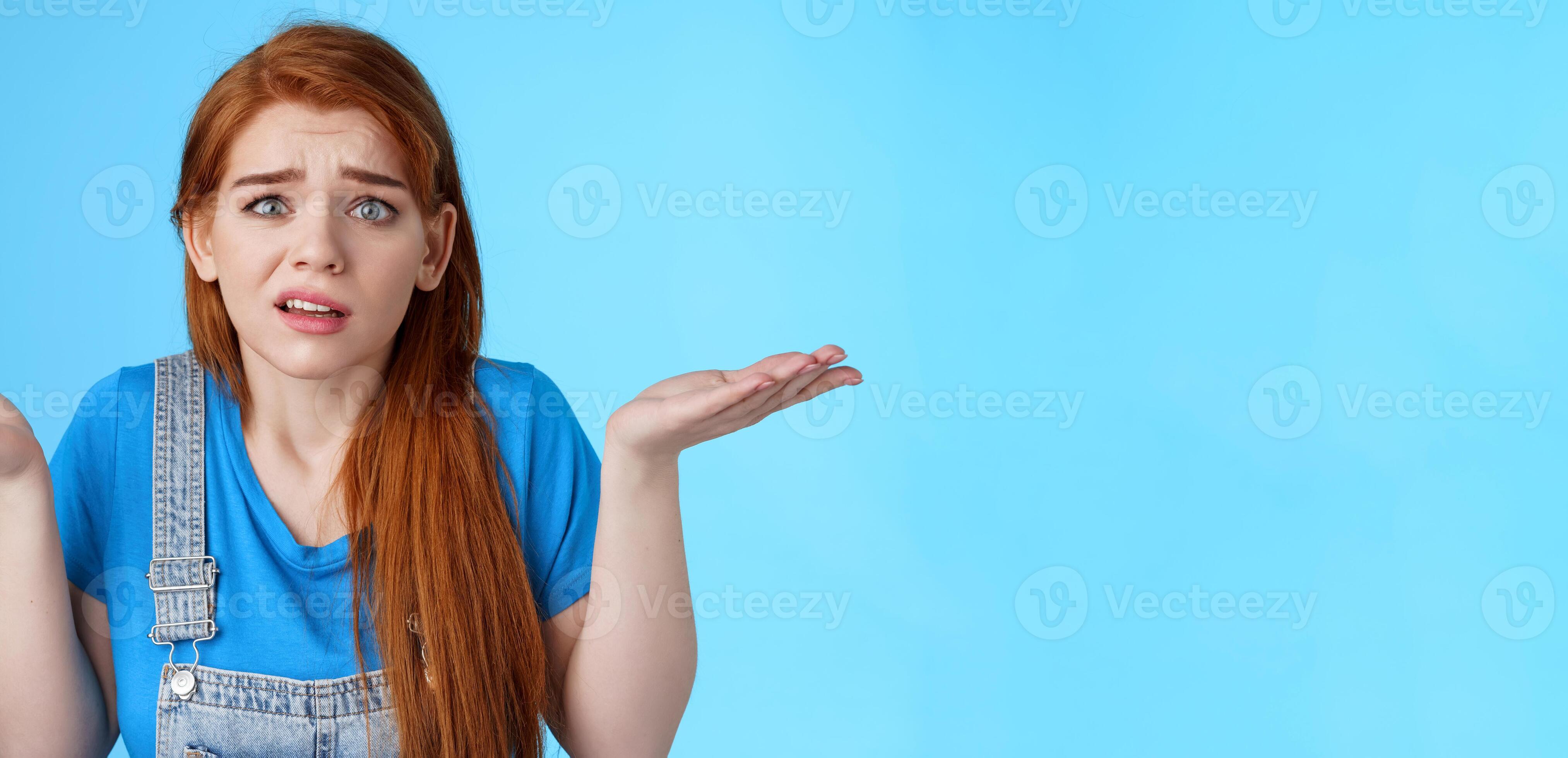 Perplexed uneasy stupified worried redhead woman shrugging, have no ...