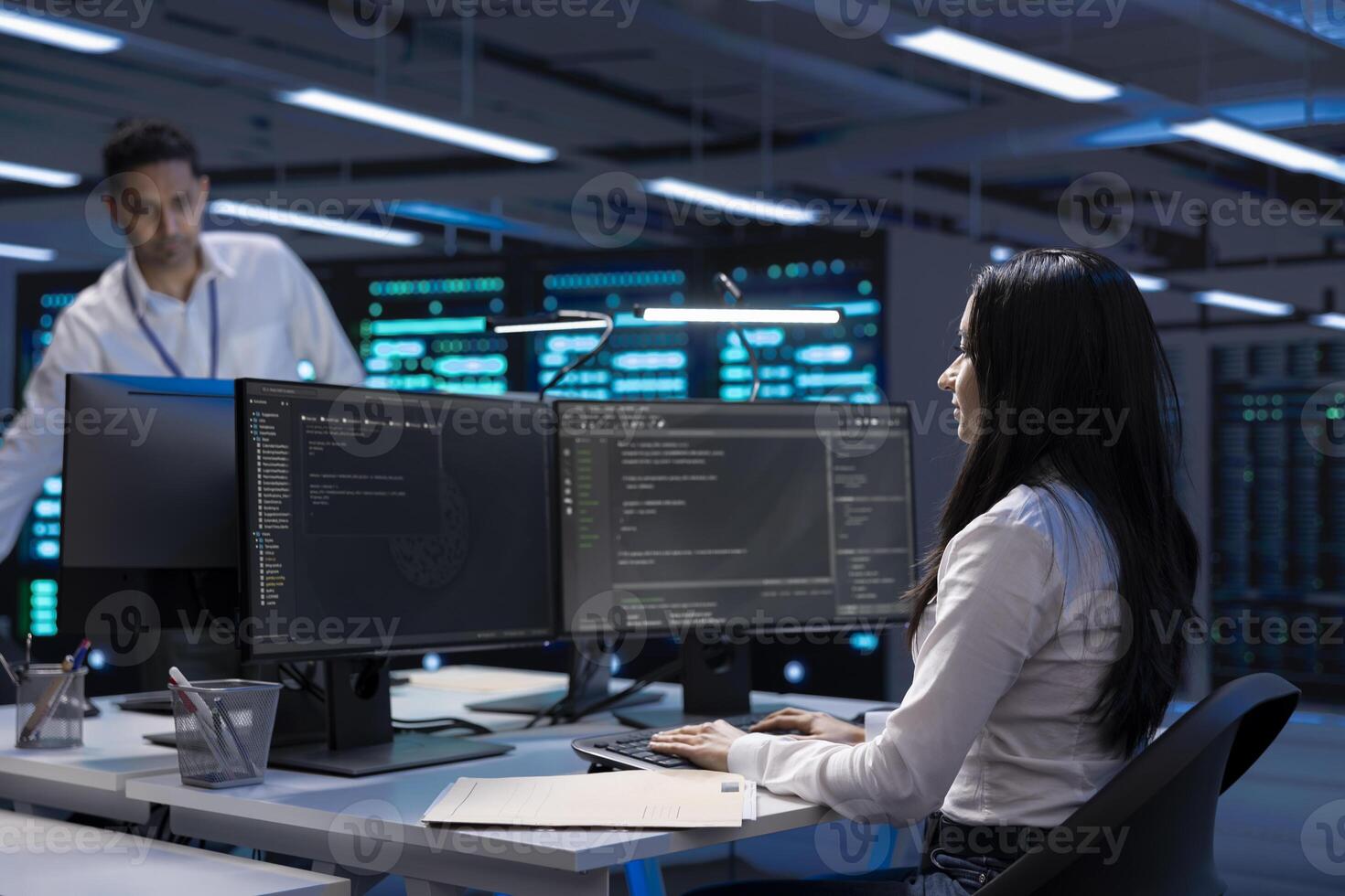 Software developer using computer, optimizing data center performance. Woman coding on PC ...