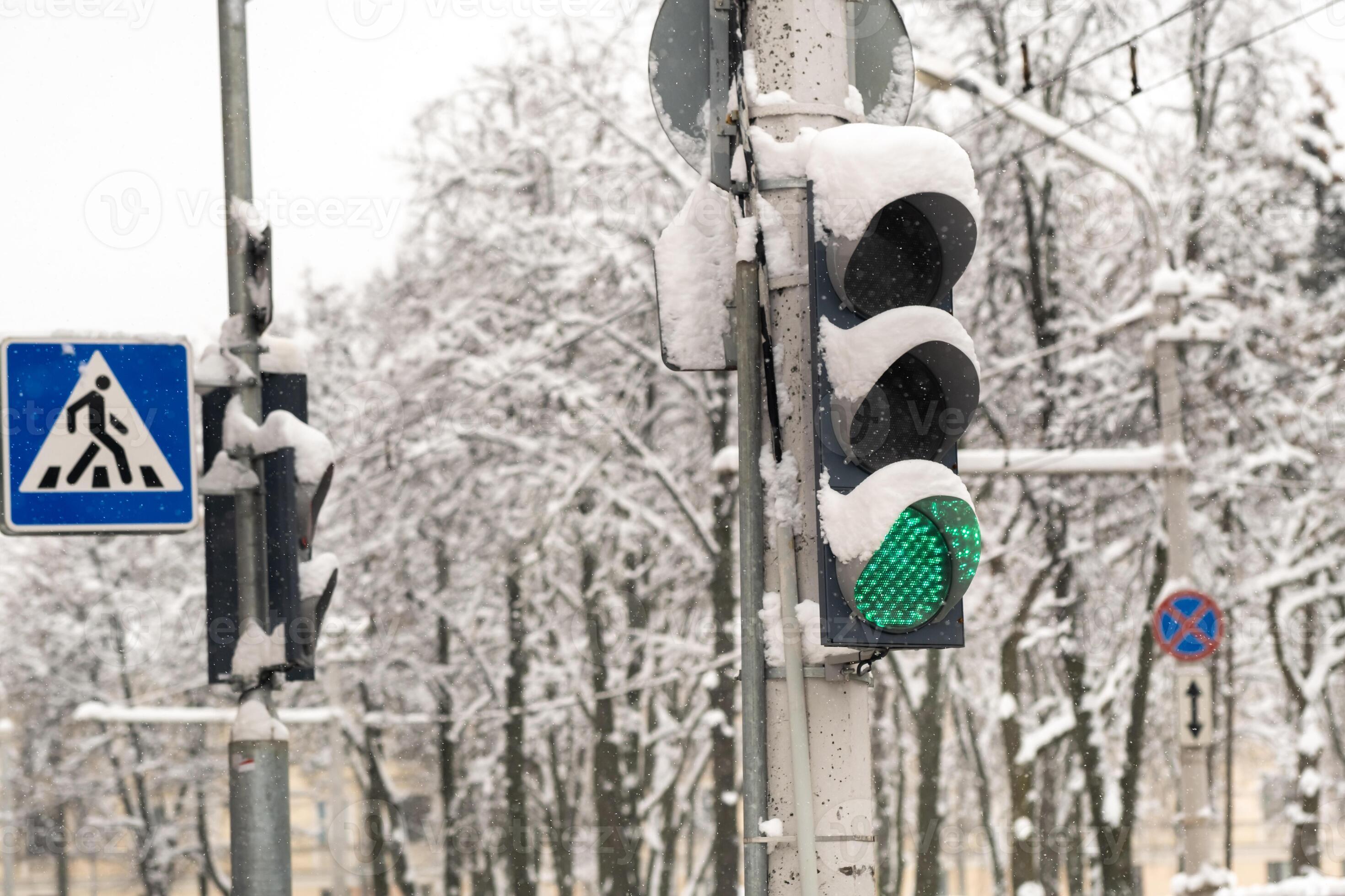A working traffic light on a city street in winter.The traffic light is ...