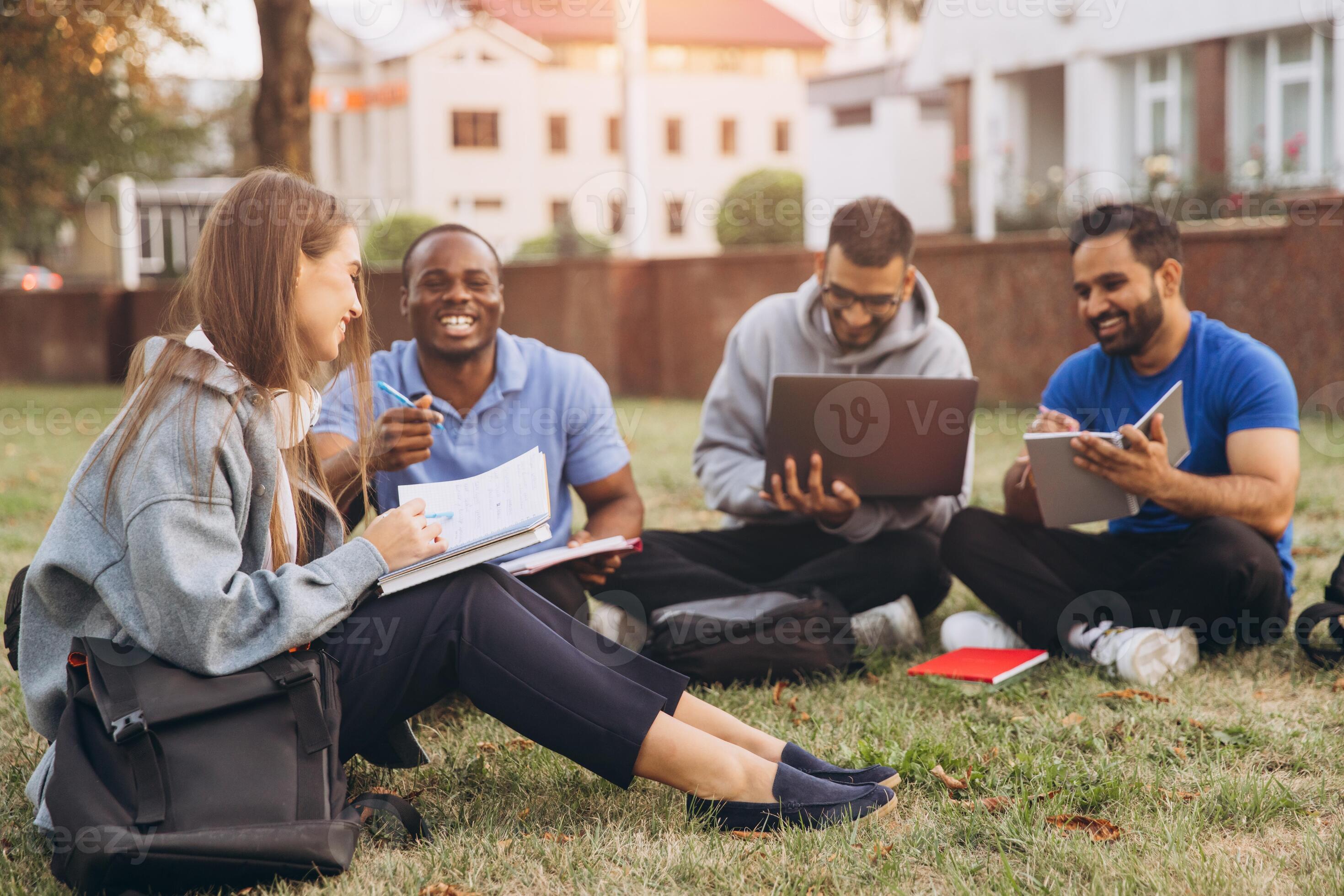 Group of Diverse Students Studying Together Outdoors on Campus While Smiling and Engaging in ...