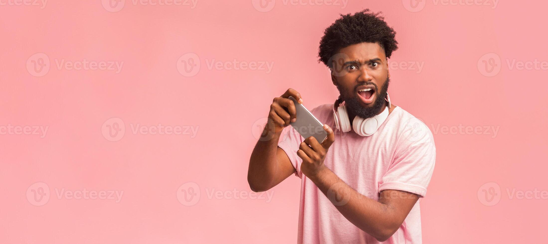 Game Addiction Emotional African American Guy Holding Phone And Playing Mobile Games Pink 1415