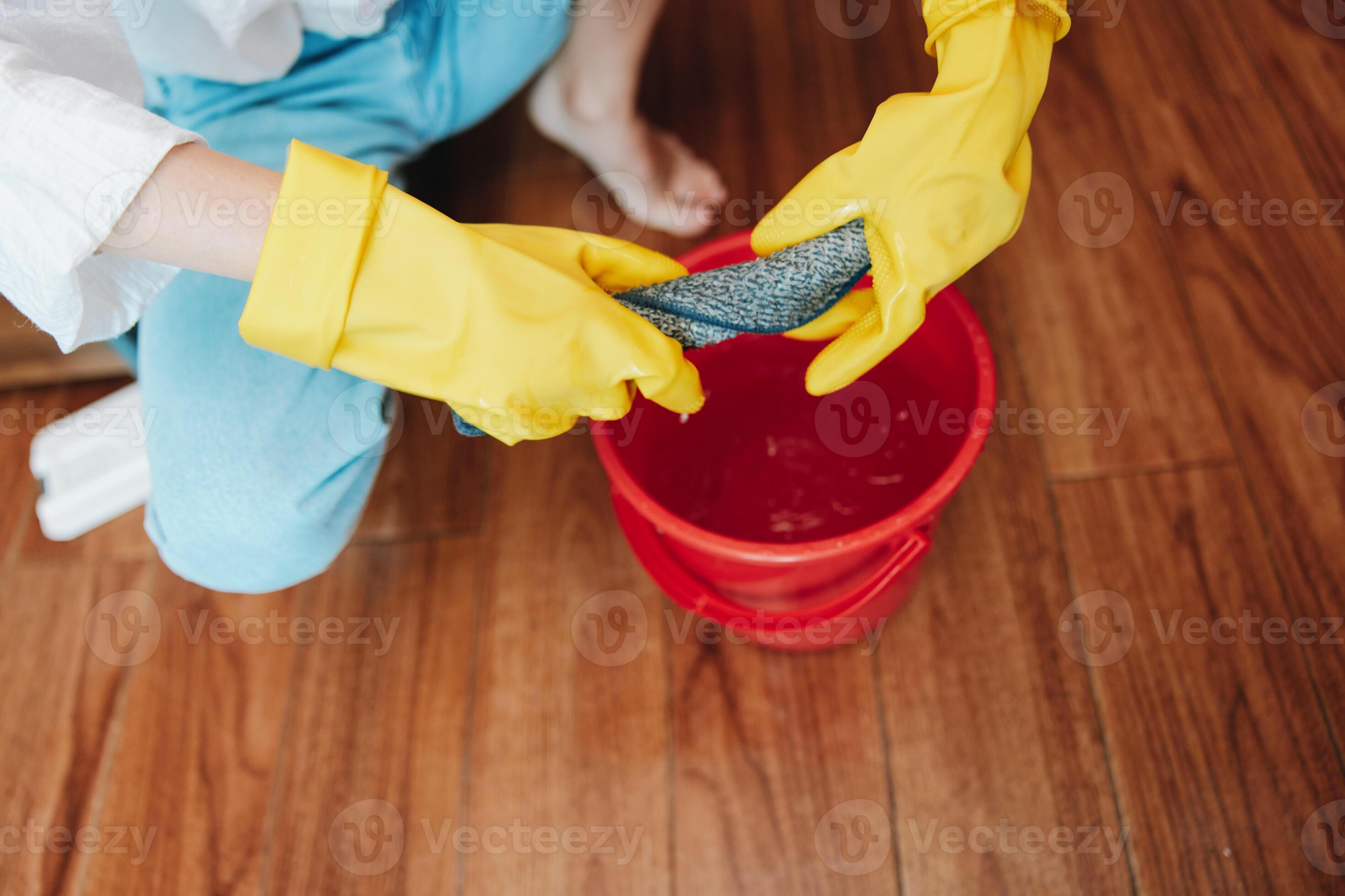 Person mopping floor in rubber gloves in front of another person ... Person mopping floor in rubber gloves in front of another person ...