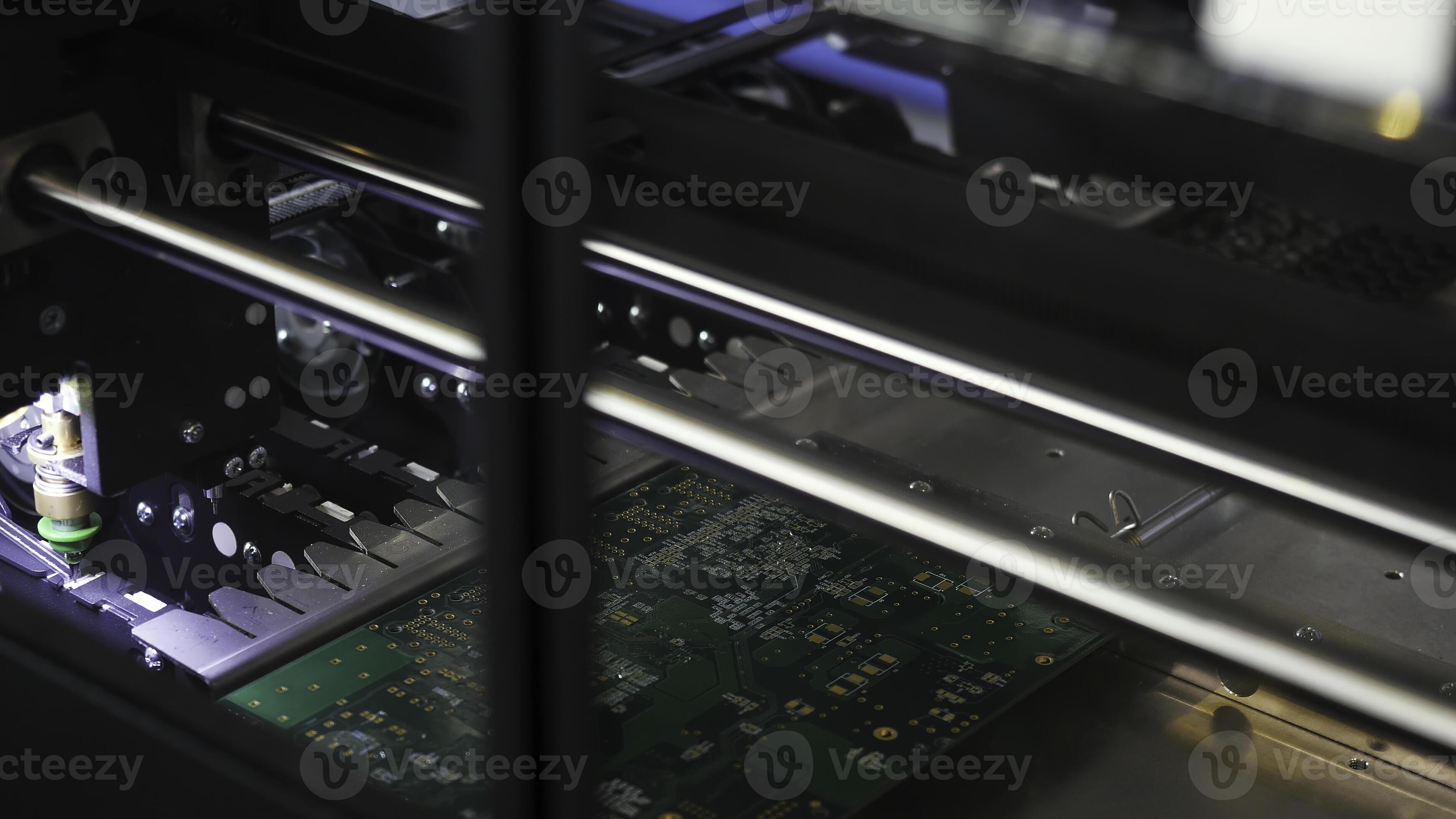 Close up for the robotic mechanism soldering the chip at the computer ...