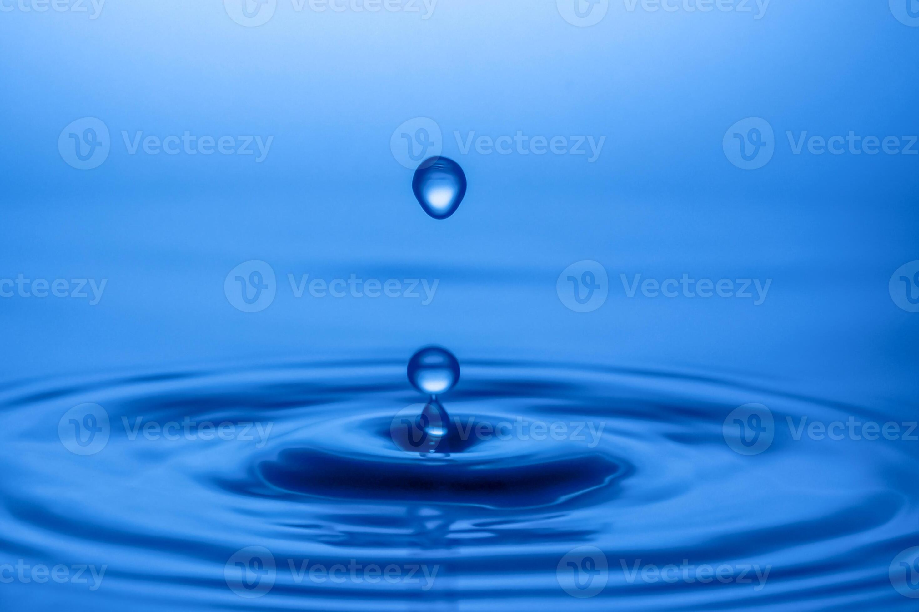Captivating Close-Up of a Water Droplet Creating Ripples on a Calm Blue Surface in Minimalist ...