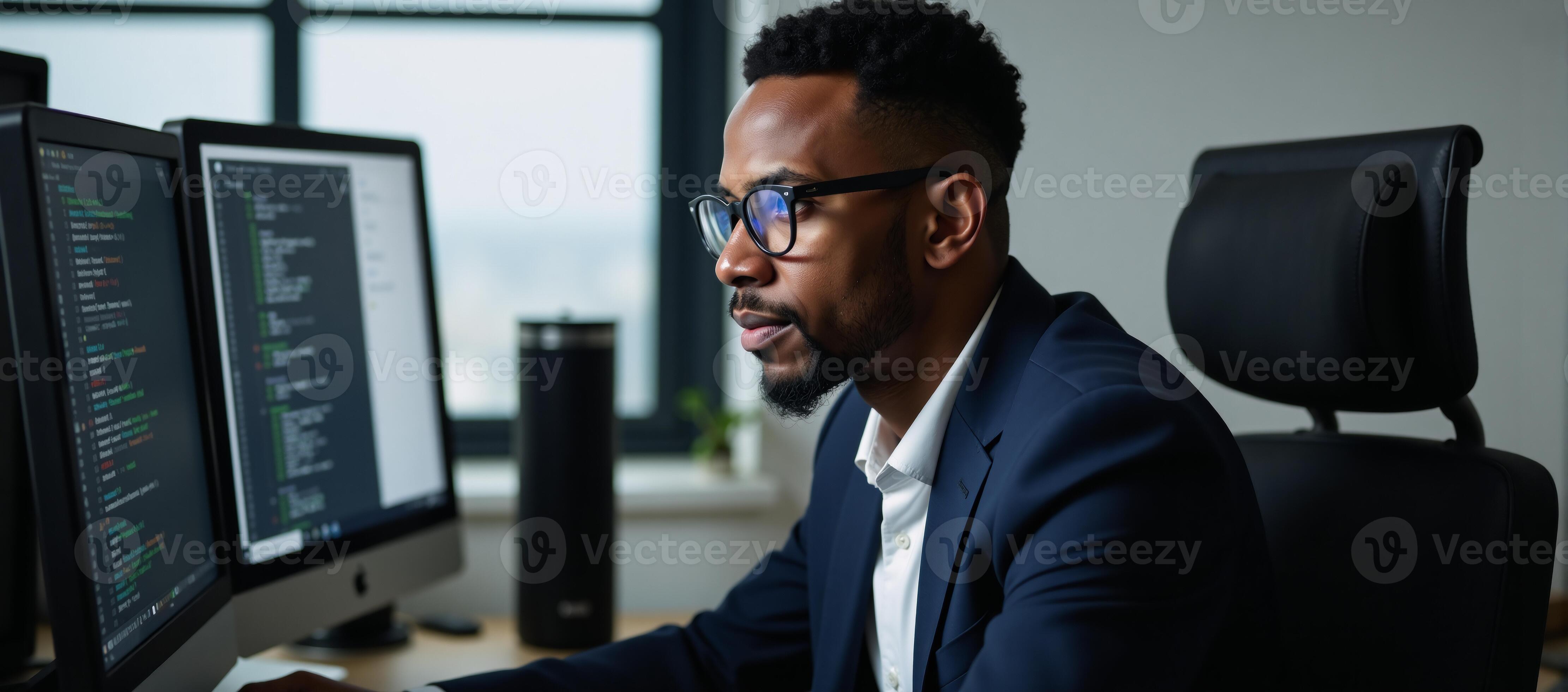 An African American male IT professional is portrayed while intensely ...