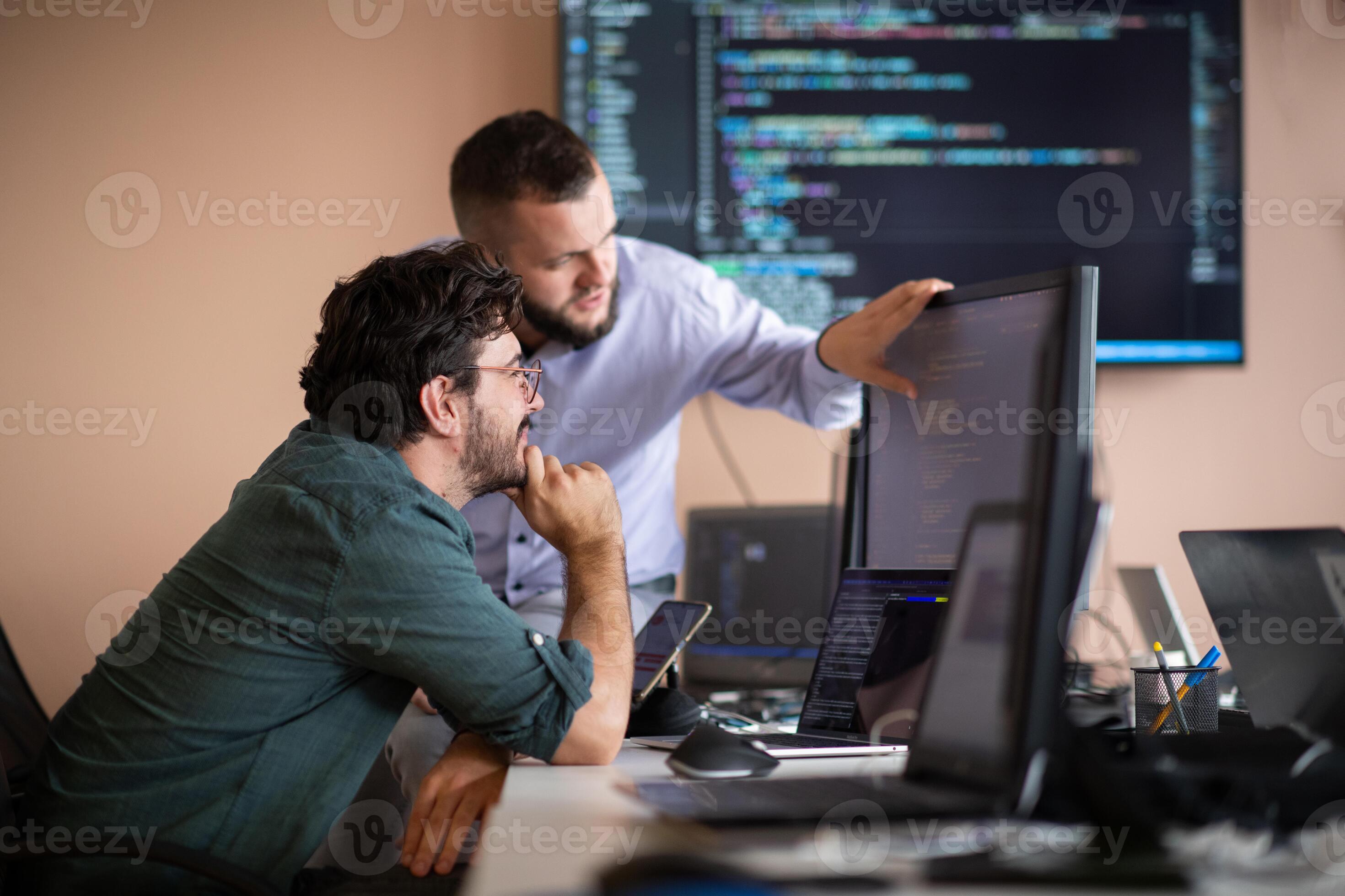 Programmers engrossed in deep collaboration, diligently working together to solve complex ...