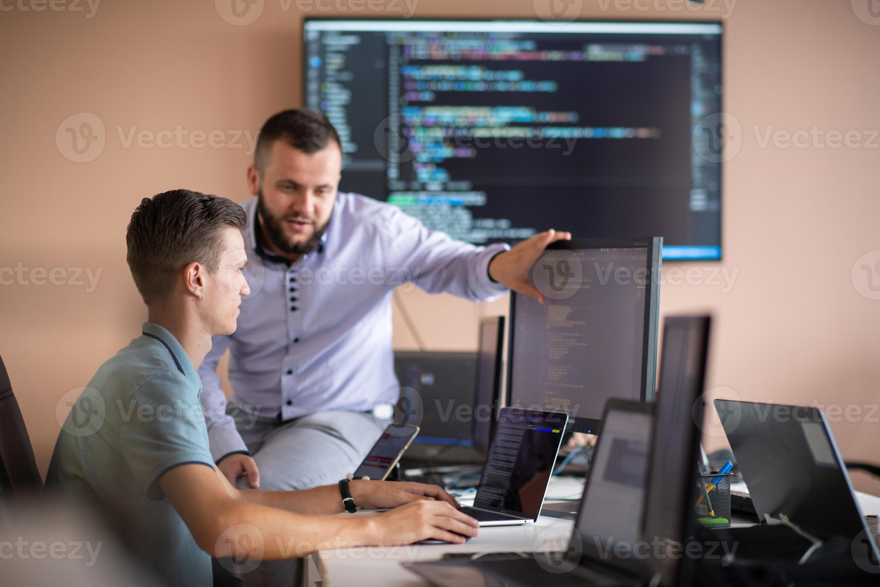 Programmers engrossed in deep collaboration, diligently working together to solve complex ...