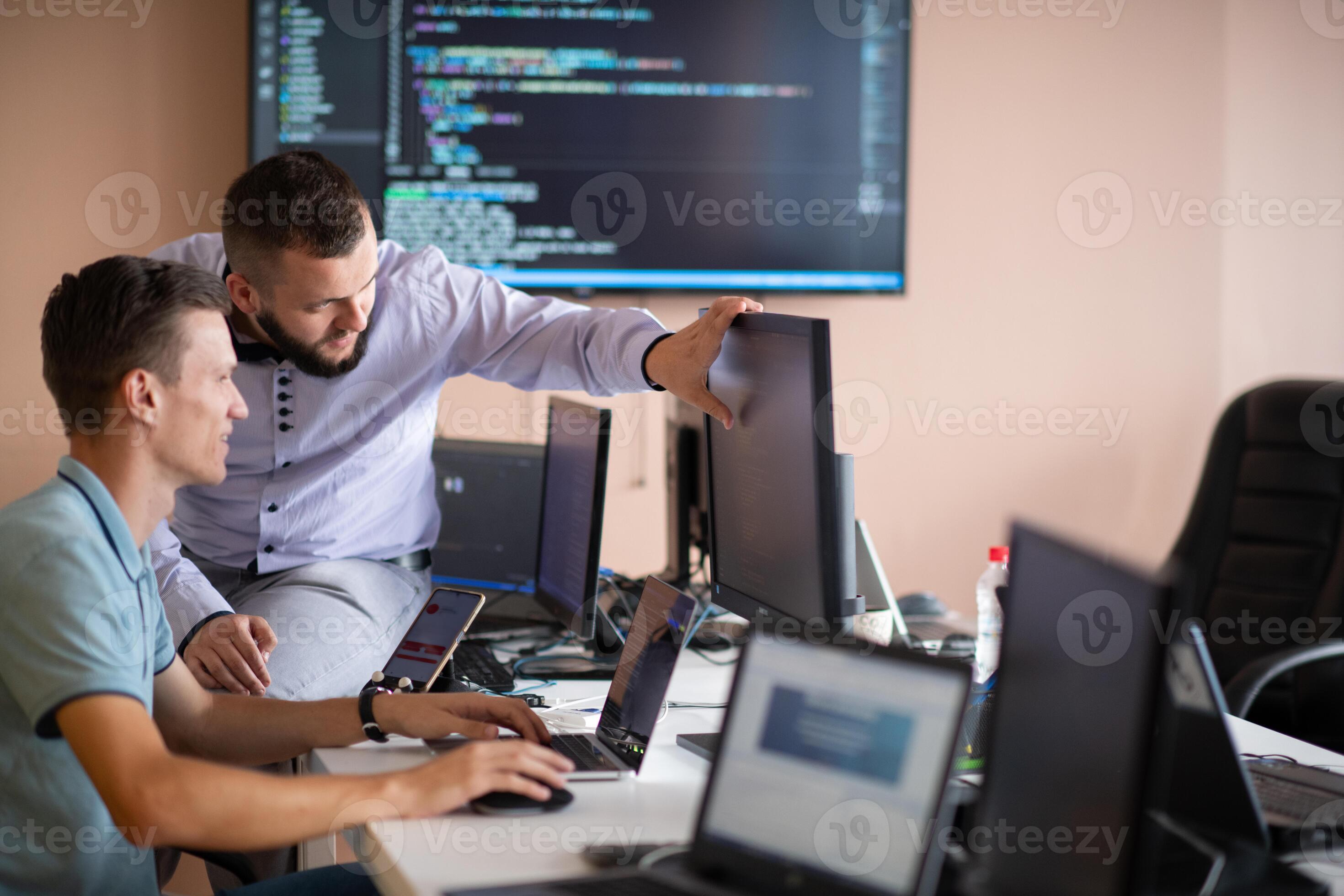 Programmers engrossed in deep collaboration, diligently working together to solve complex ...