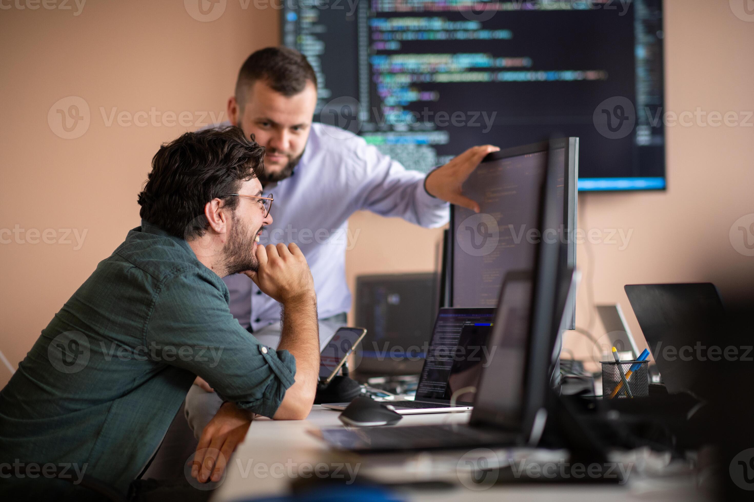 Programmers engrossed in deep collaboration, diligently working together to solve complex ...
