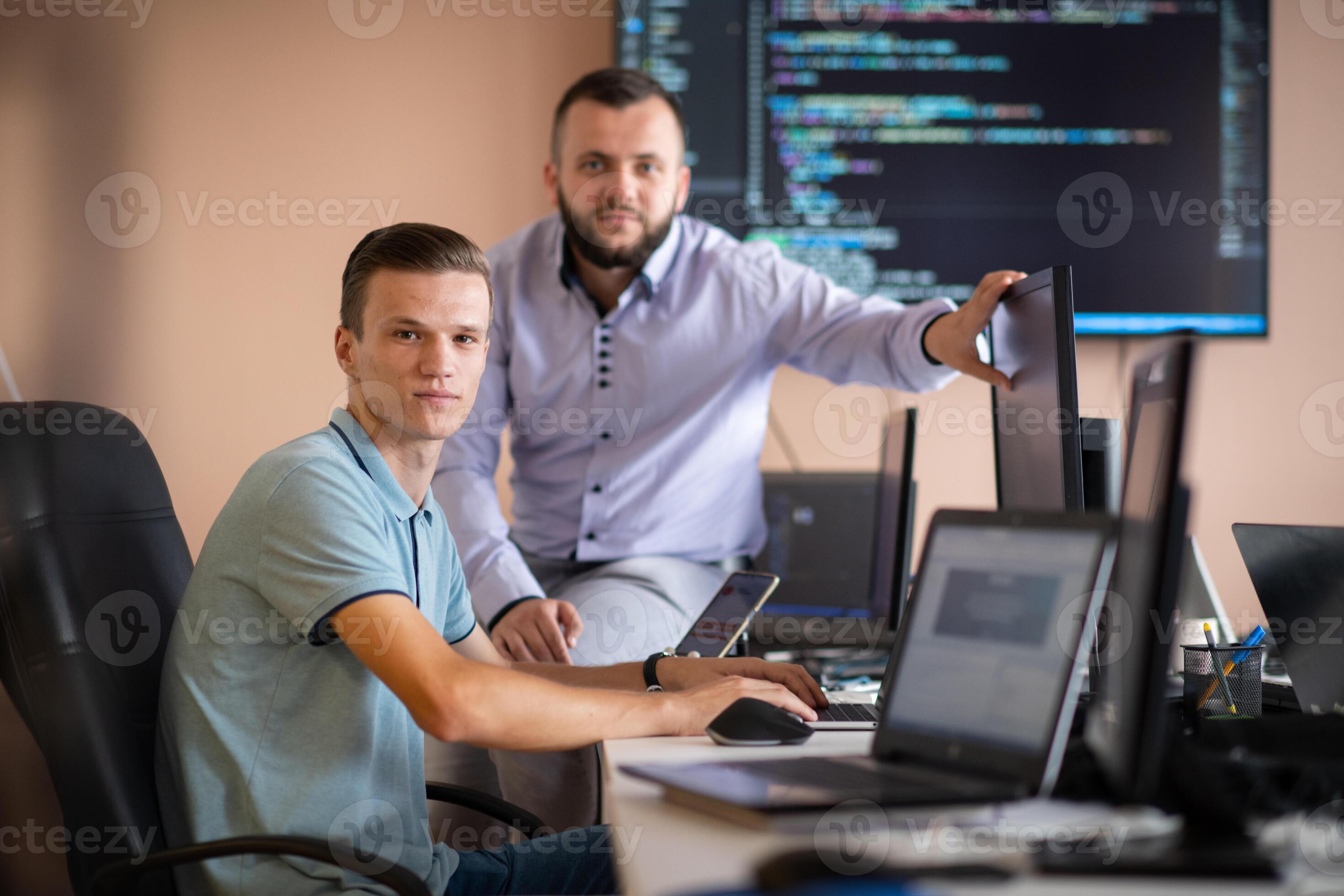 Programmers engrossed in deep collaboration, diligently working together to solve complex ...