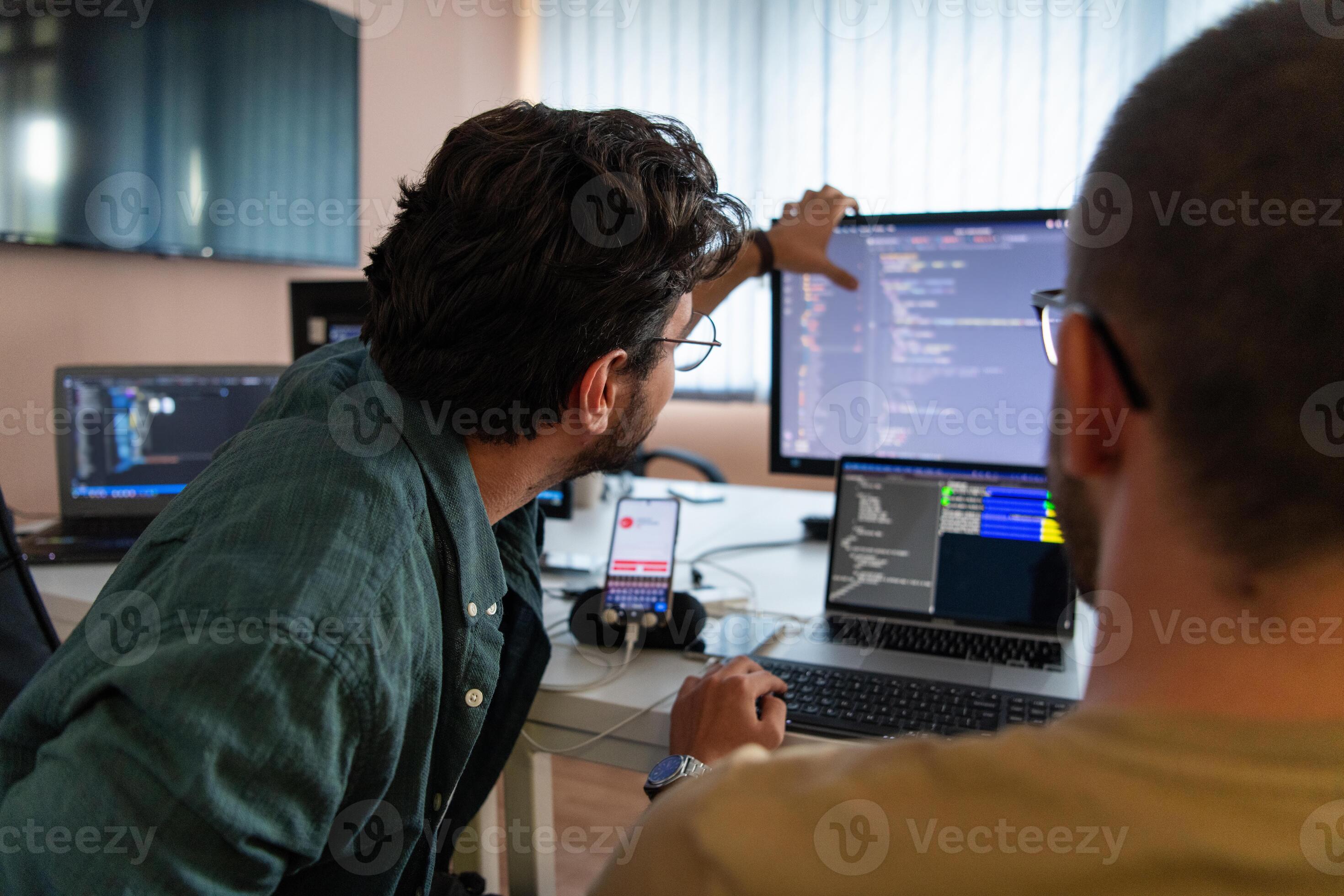 Programmers engrossed in deep collaboration, diligently working together to solve complex ...