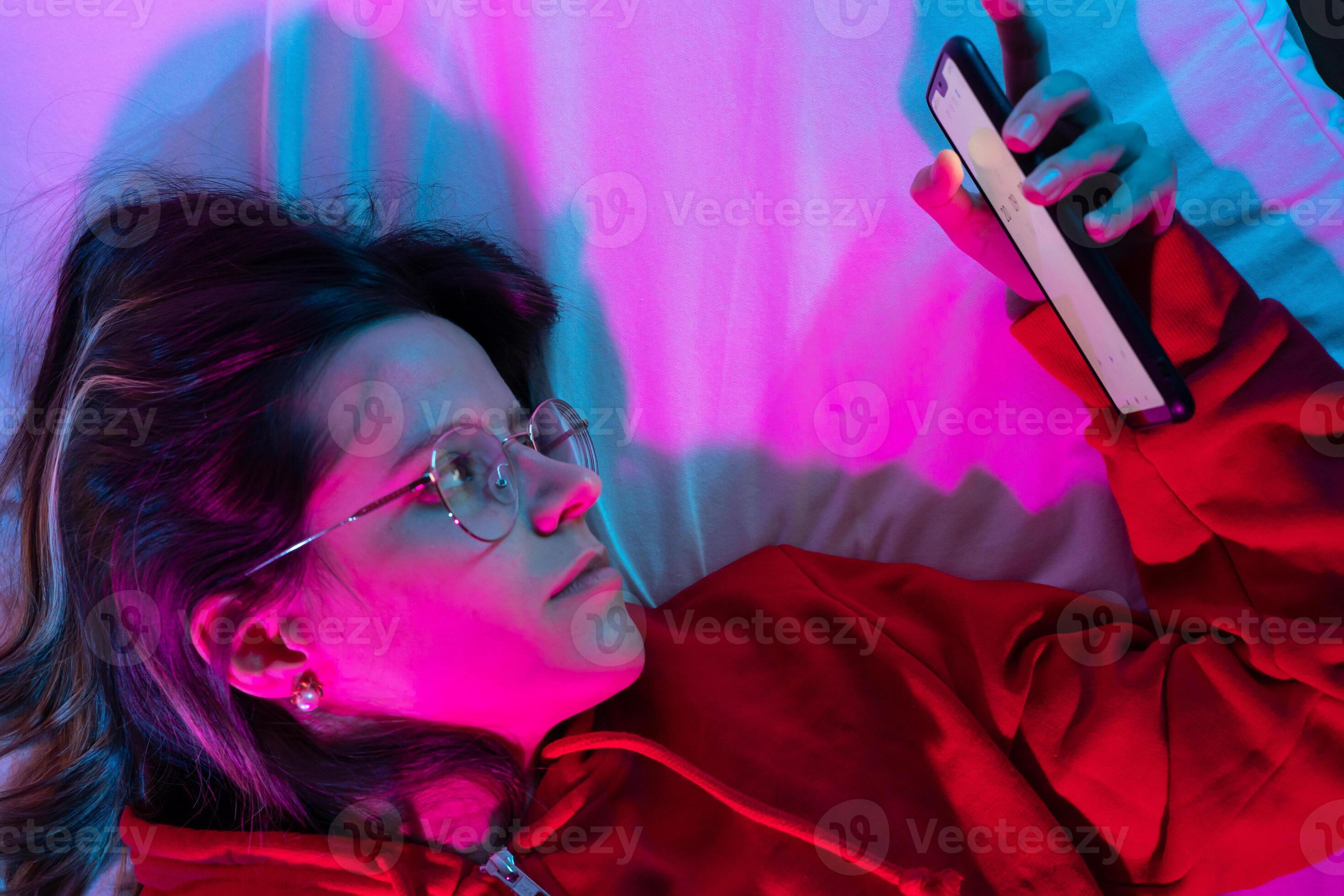Doom scrolling on bed at night with neon lights. Technology at bed concept. 51790227 Stock Photo ...