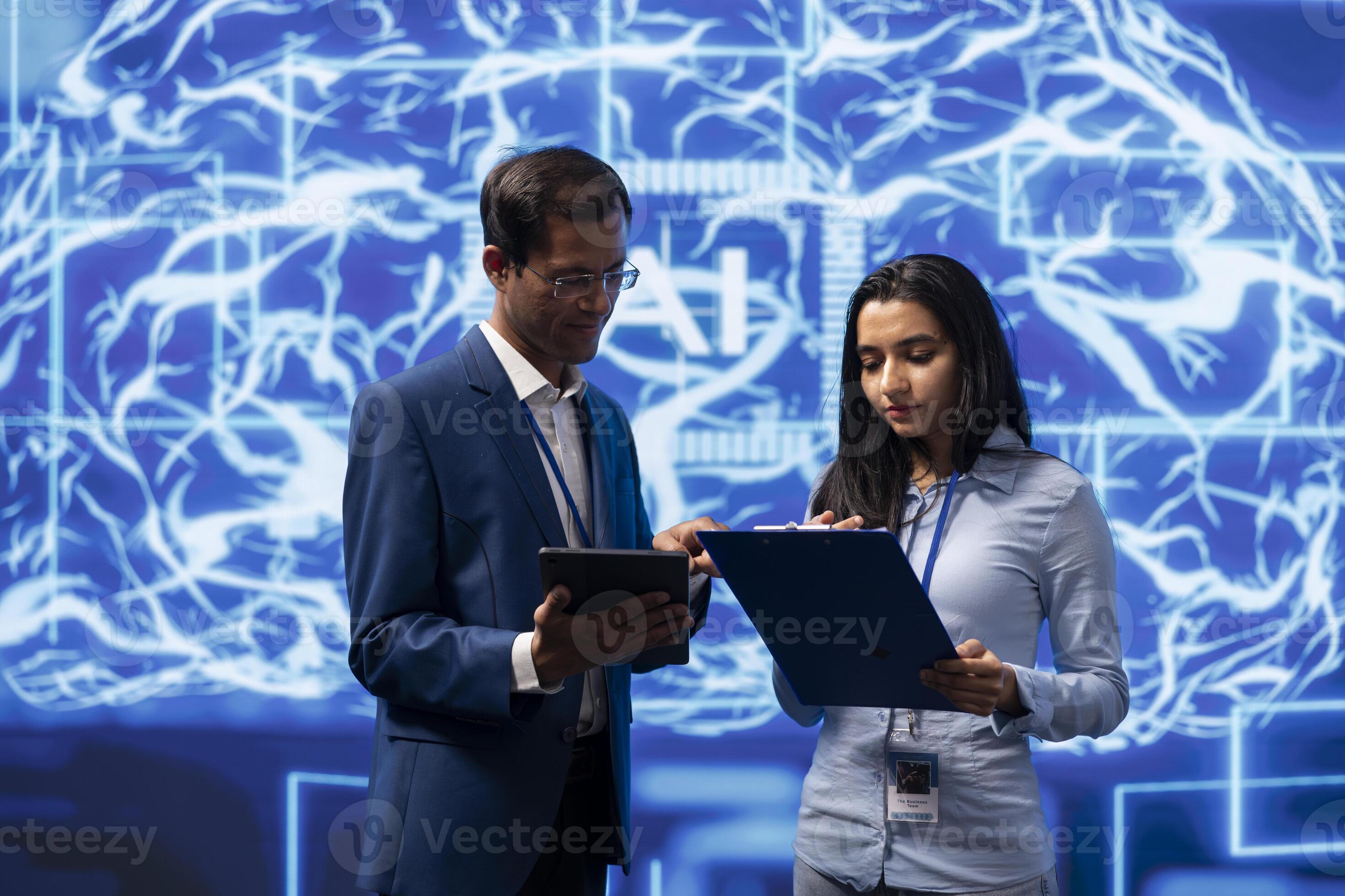 IT department coworkers solving tasks on laptop and tablet, running artificial intelligence ...