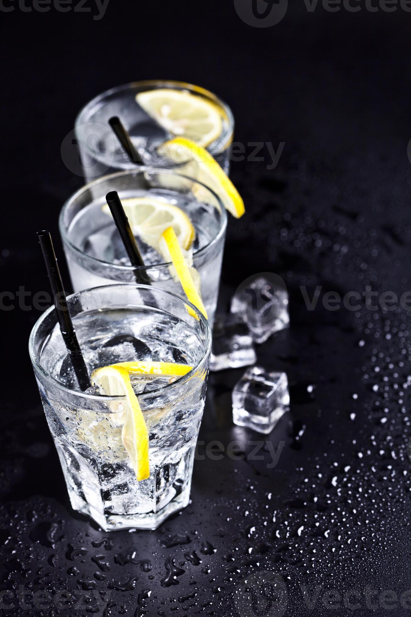 Three glasses with fresh cold carbonated water with lemon slices and ice cubes closeup. 52039319 ...