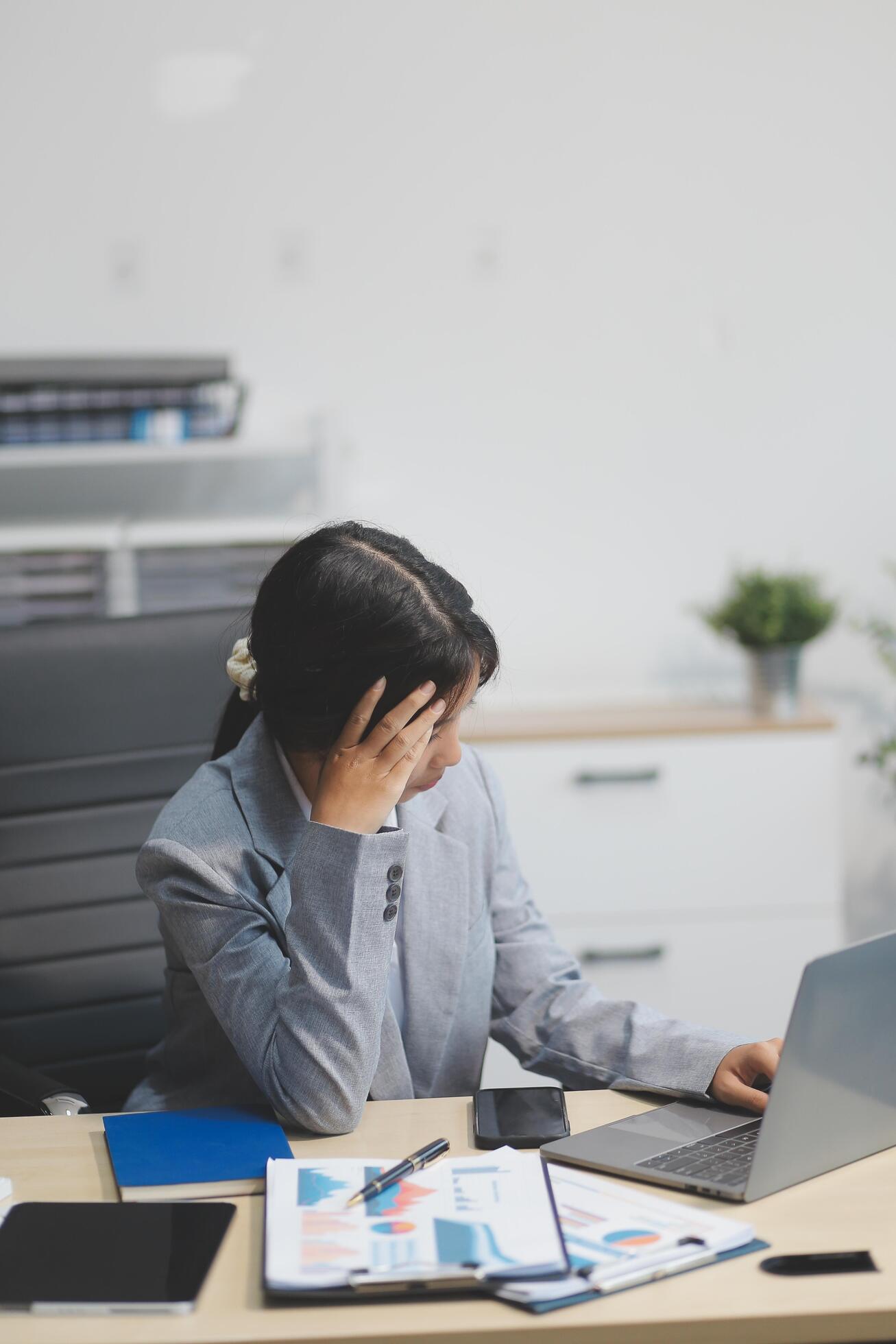 las mujeres asiáticas están estresadas mientras trabajan en una laptop, una mujer de negocios ...