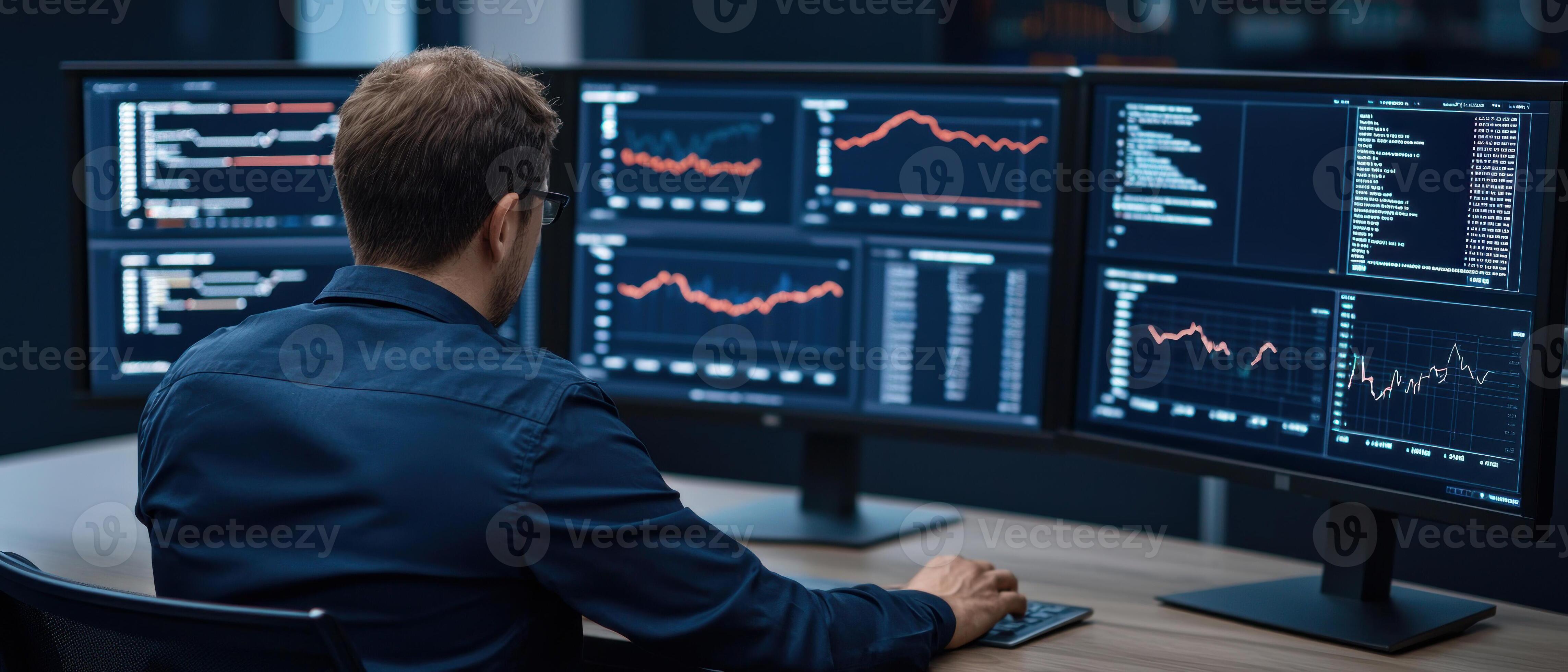 A focused professional analyzes complex data on multiple computer monitors. 53112566 Stock Photo ...