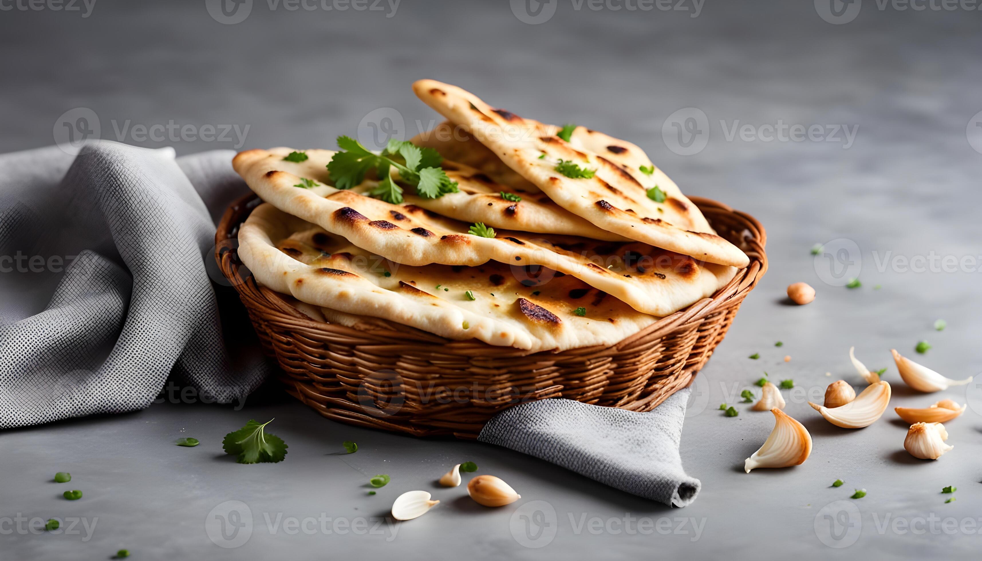 Crispy garlic naan in a basket isolated on napkin side view on grey background famous indian and ...