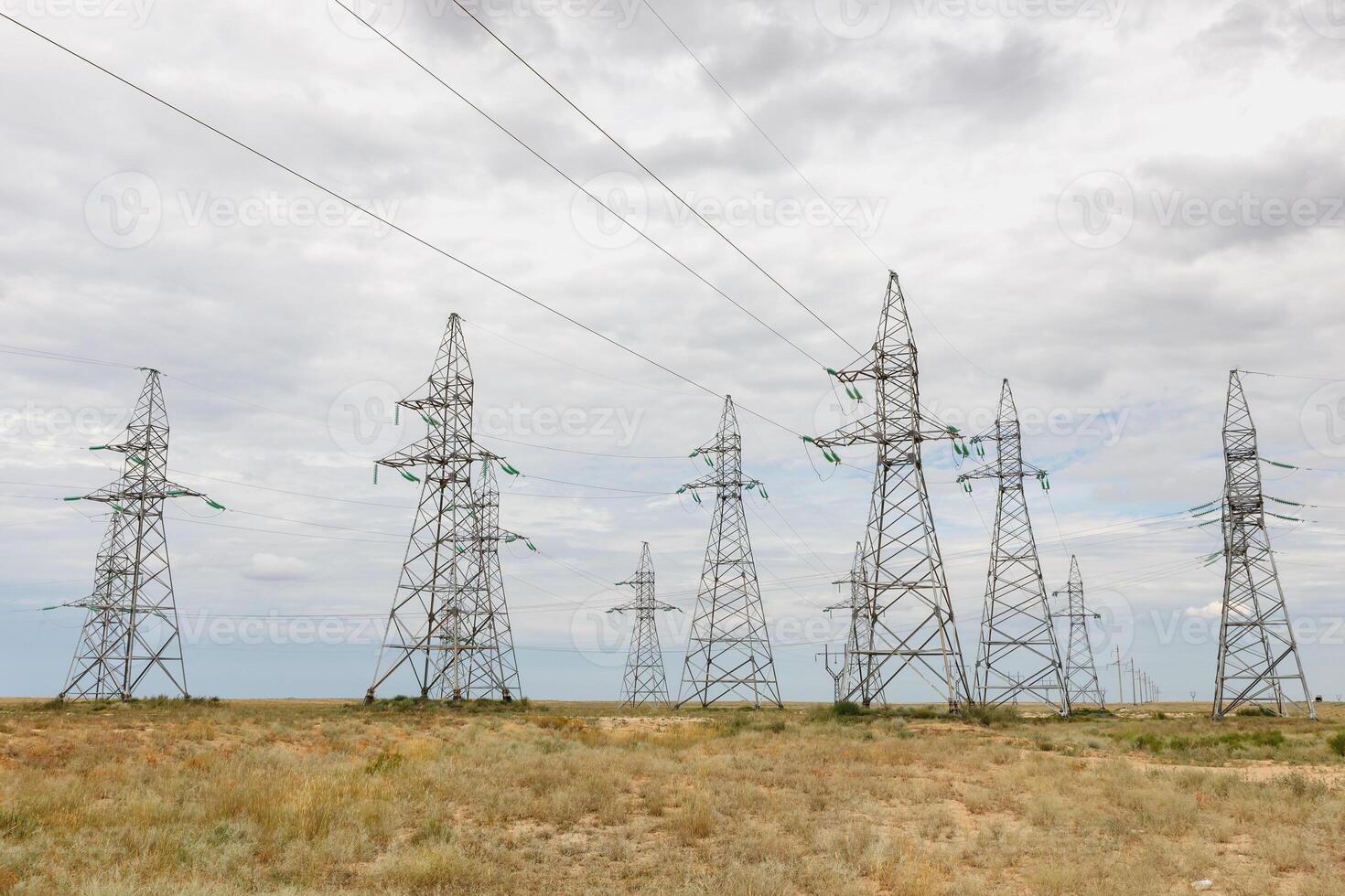 Electricity transmission towers stand tall against a cloudy sky in a rural landscape 53331413 ...