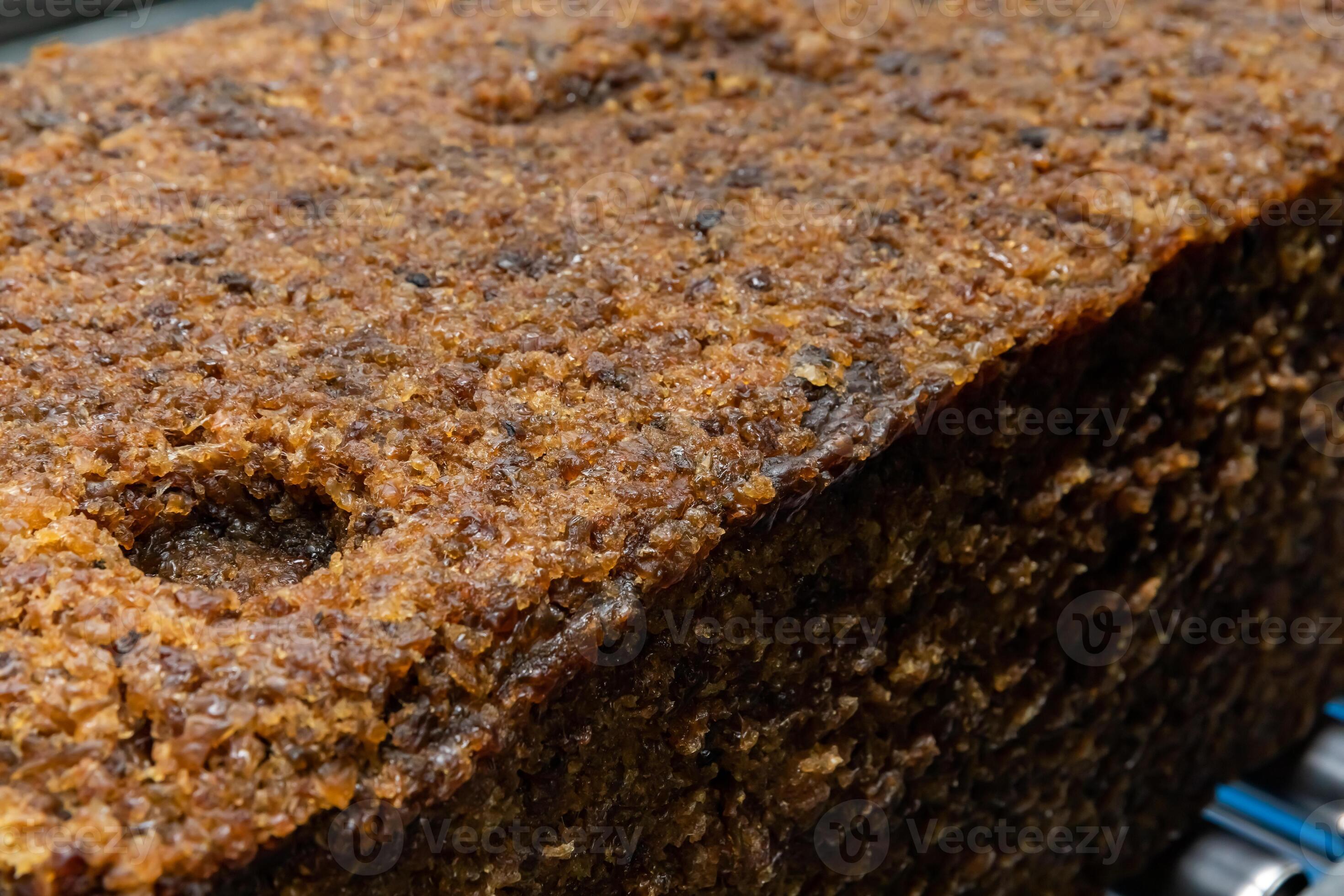 The close up image of the jagged brown natural raw rubber bales surface, lumpy solid block ...