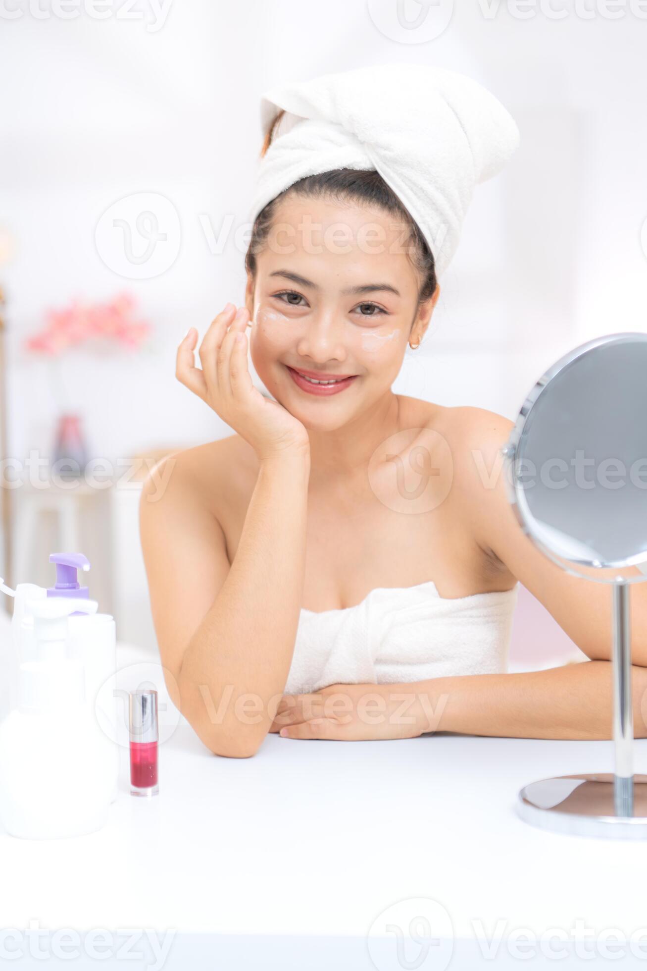 Asian young woman with towel wrapped on head and body applying makeup ... Asian young woman with towel wrapped on head and body applying makeup ...