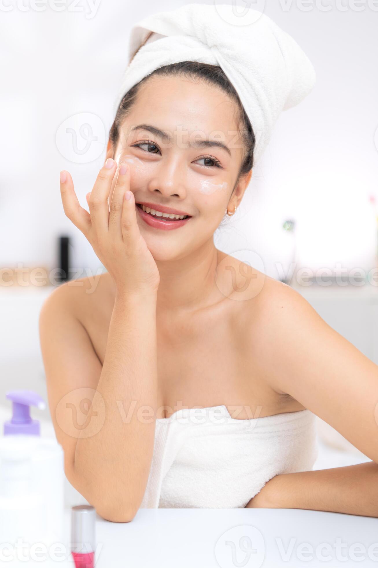 Asian young woman with towel wrapped on head and body applying makeup ... Asian young woman with towel wrapped on head and body applying makeup ...
