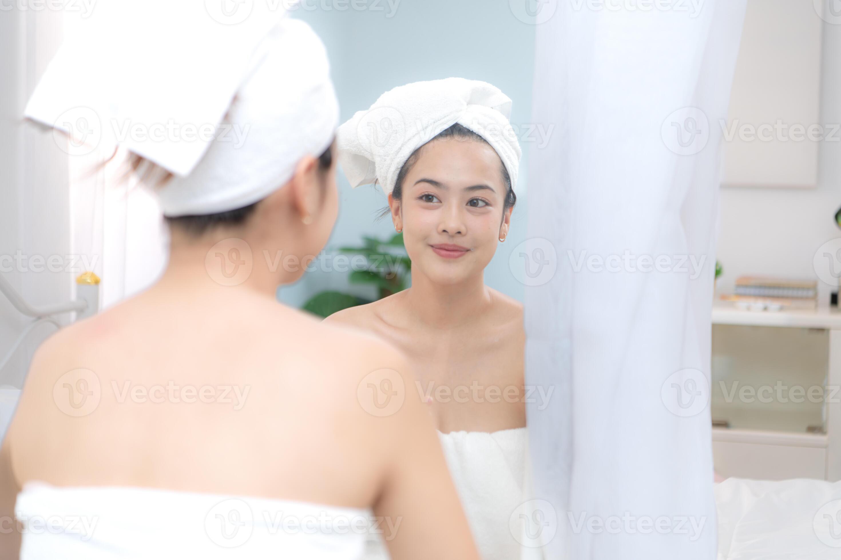 Asian young woman with towel wrapped on head and body applying makeup ... Asian young woman with towel wrapped on head and body applying makeup ...