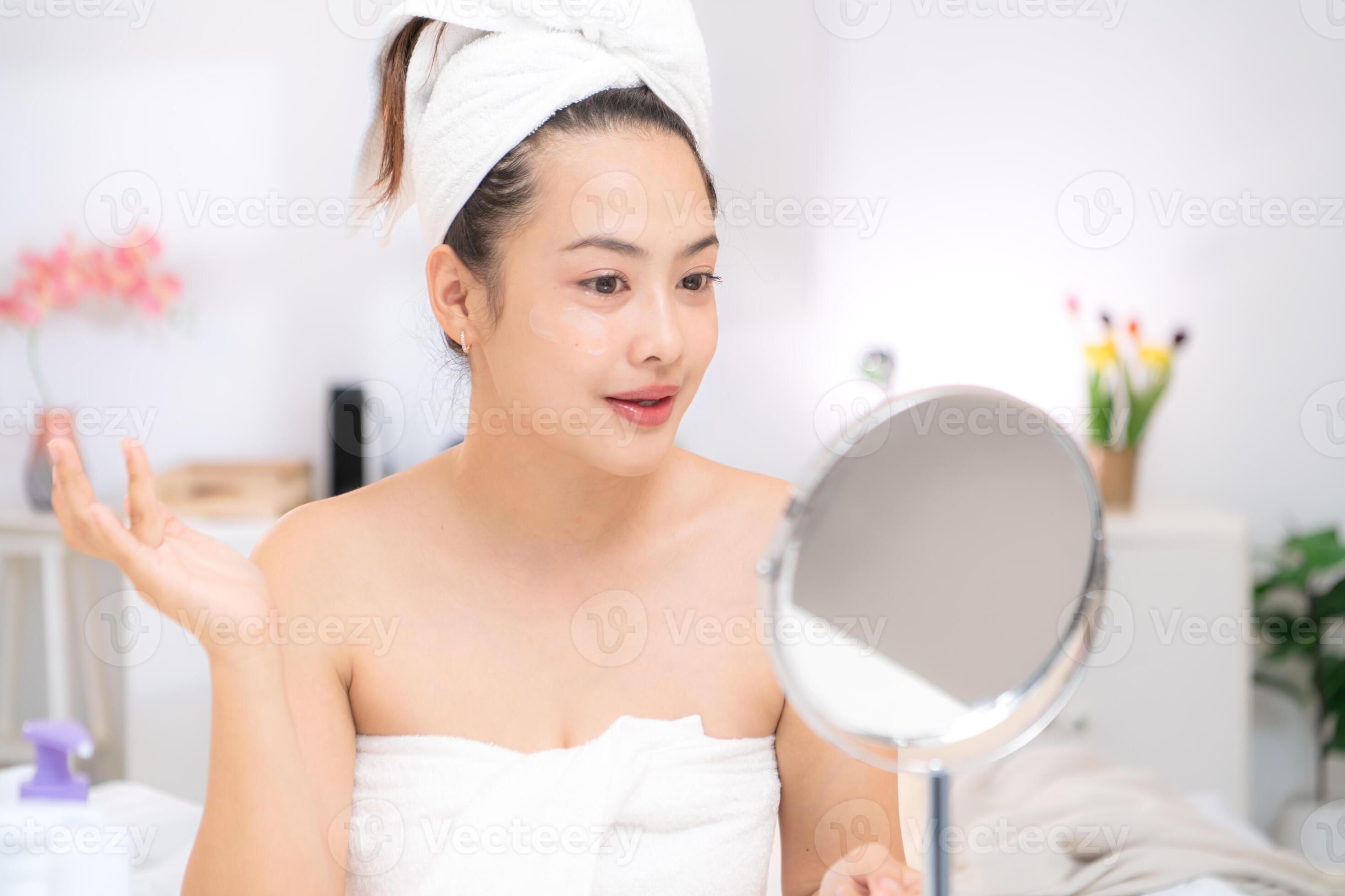 Asian young woman with towel wrapped on head and body applying makeup ... Asian young woman with towel wrapped on head and body applying makeup ...