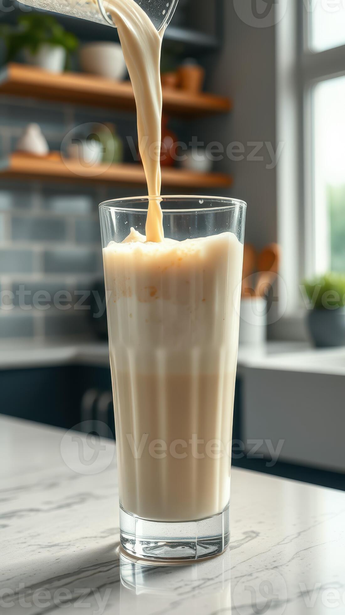 Delicious creamy drink being poured into a tall glass in a modern kitchen setting 53877862 Stock ...