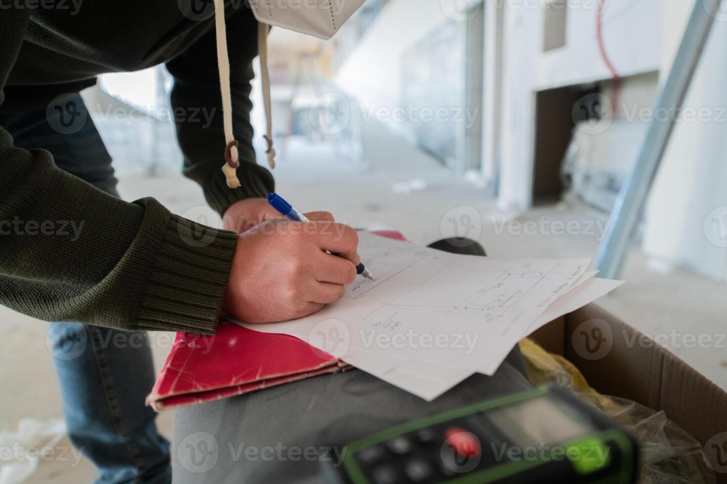 A close-up of an engineer's hand meticulously sketching an architectural project, capturing the ...