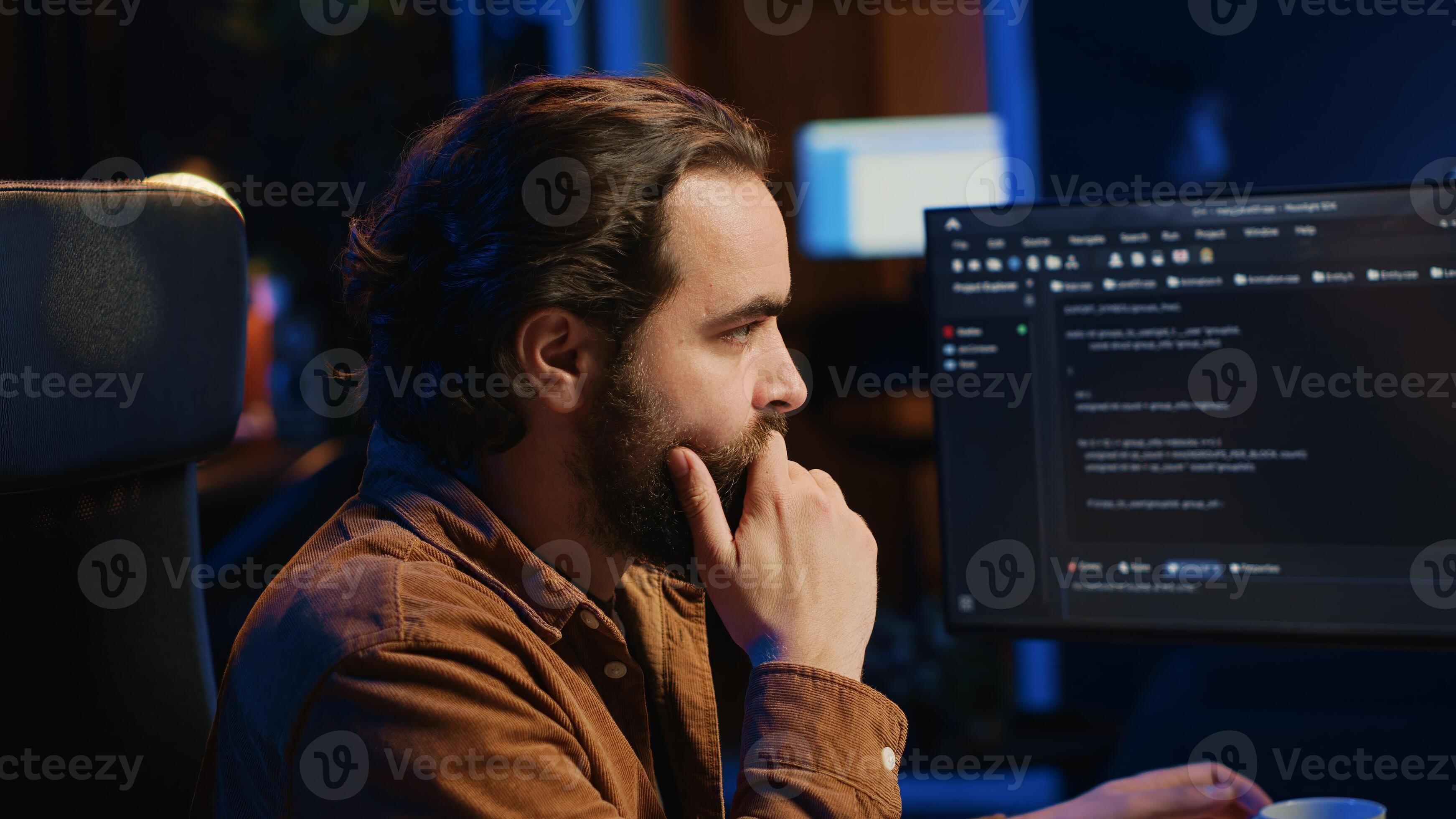 Computer scientist drinking cup of coffee while developing code on PC using java programming ...