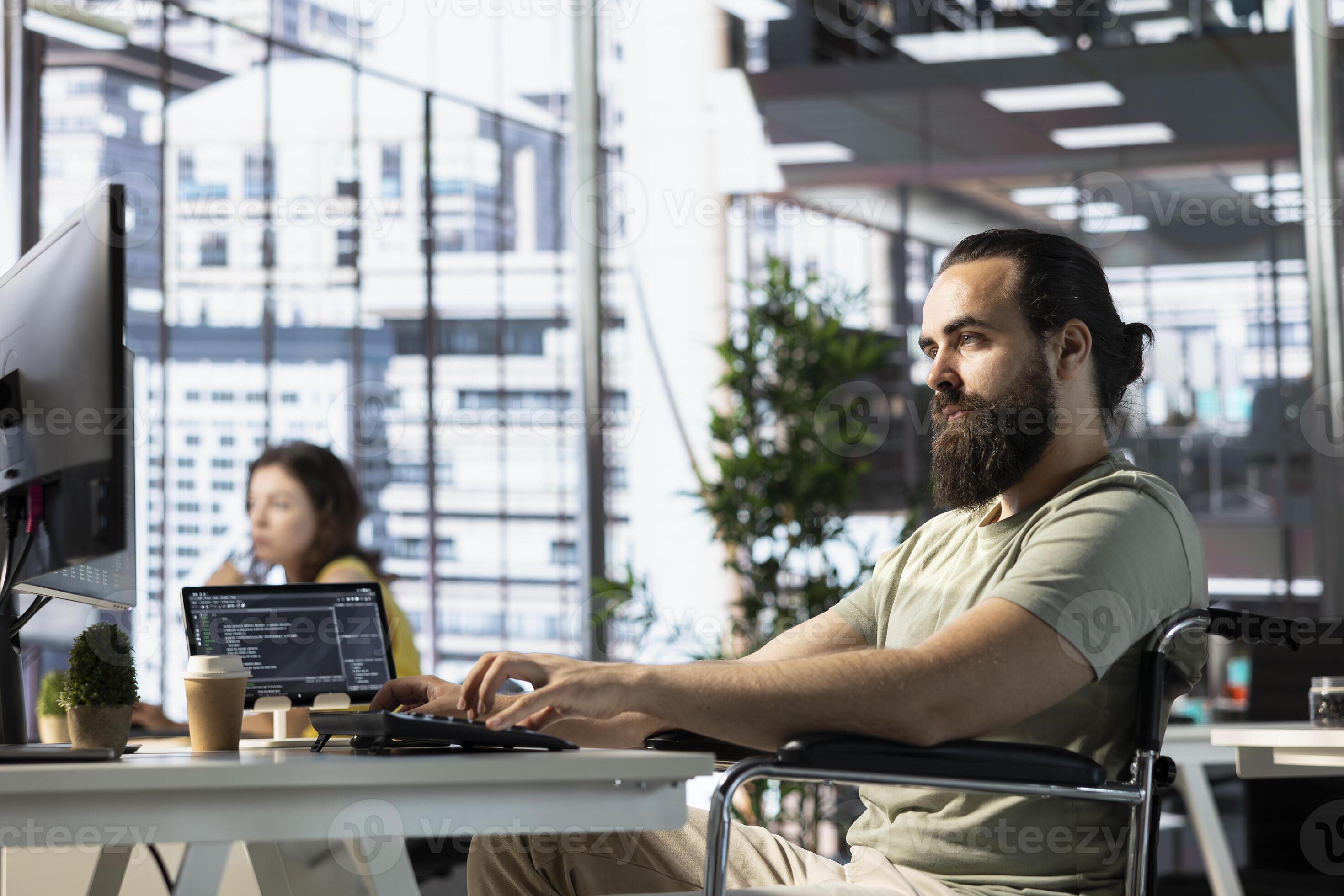 Developer with disability sitting in wheelchair fixing applications issues, dealing with ...