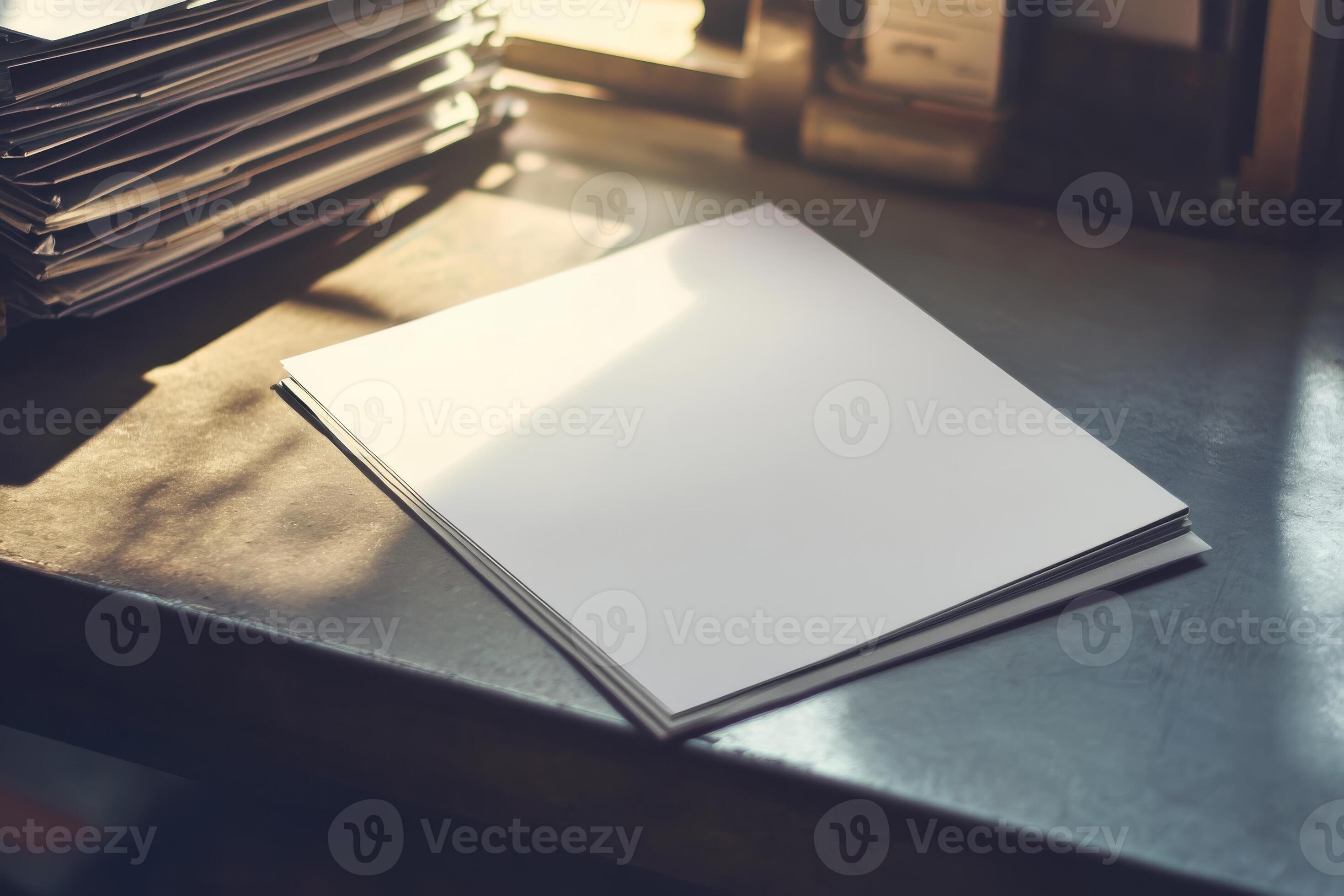 Stack of blank white papers on a wooden desk in sunlight reflecting ...