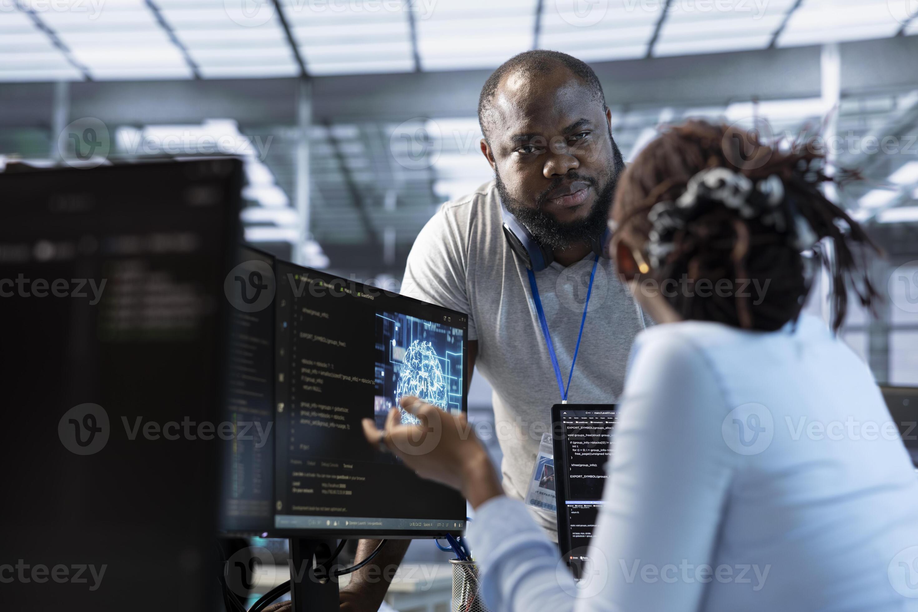 System administrator working with colleague in data center facility providing computing ...
