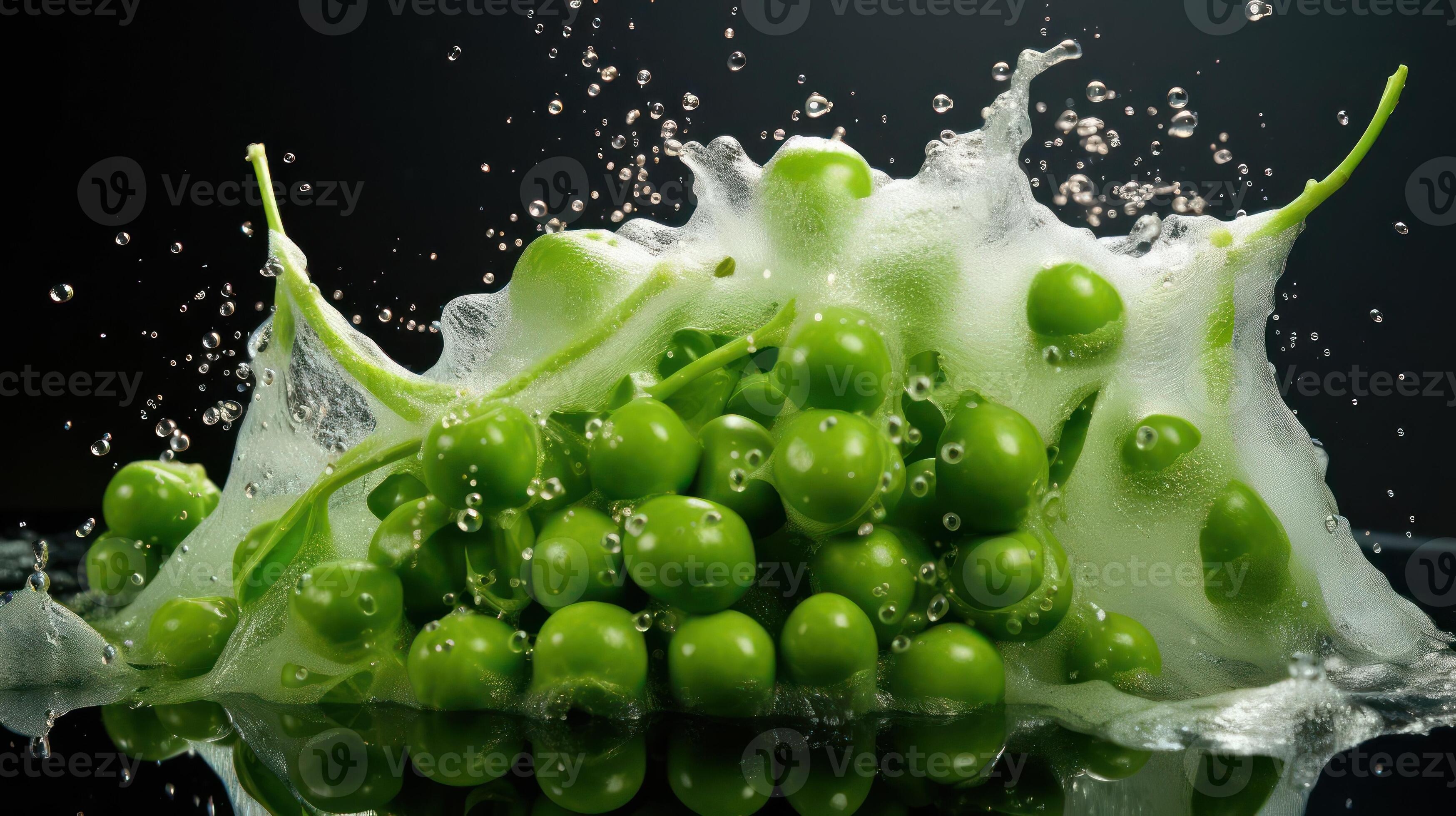 A close-up photograph of a splash of water with green peas inside ...