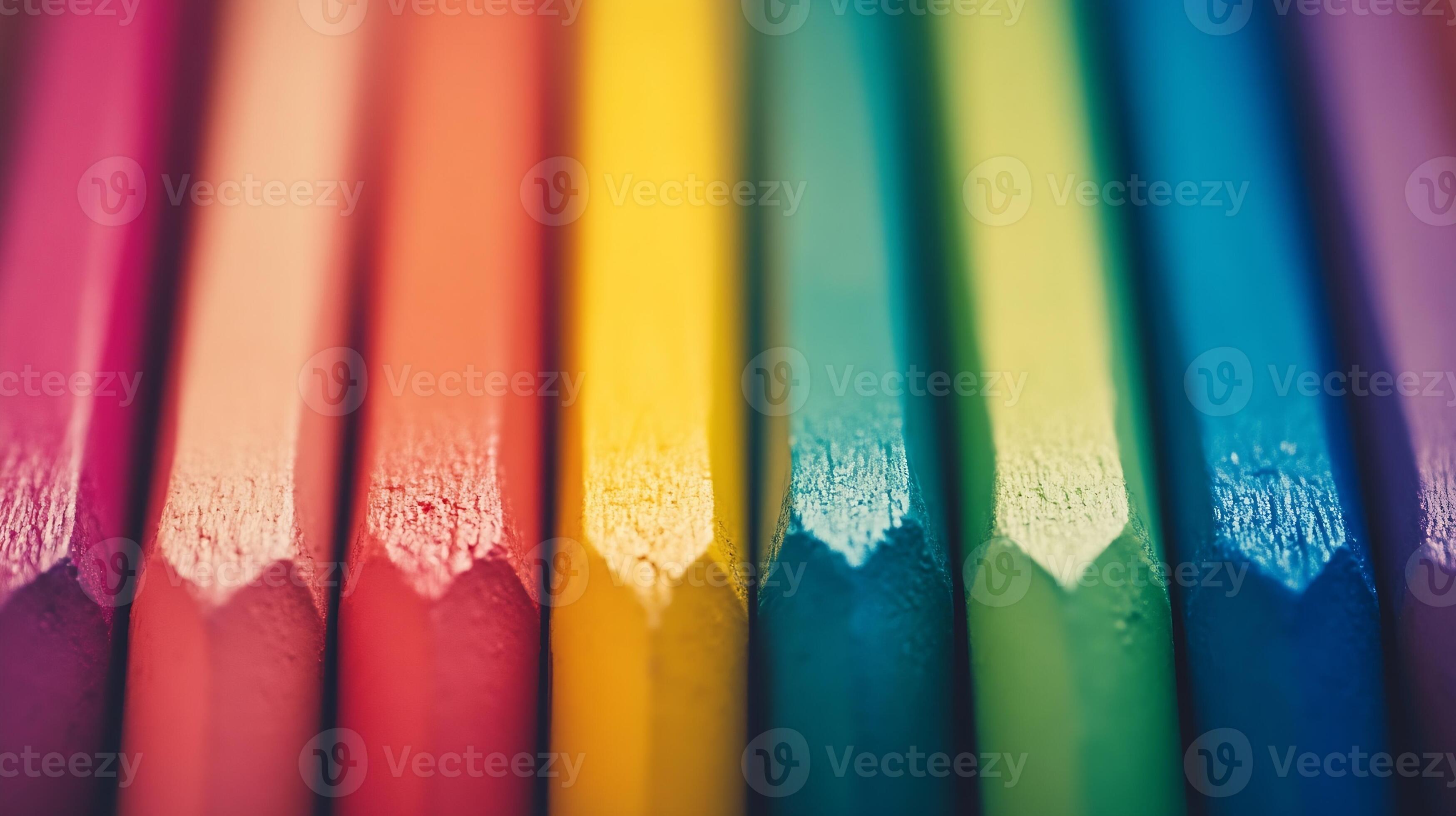 Vibrant collection of sharpened colored pencils lined up showing a spectrum of rainbow colors ...