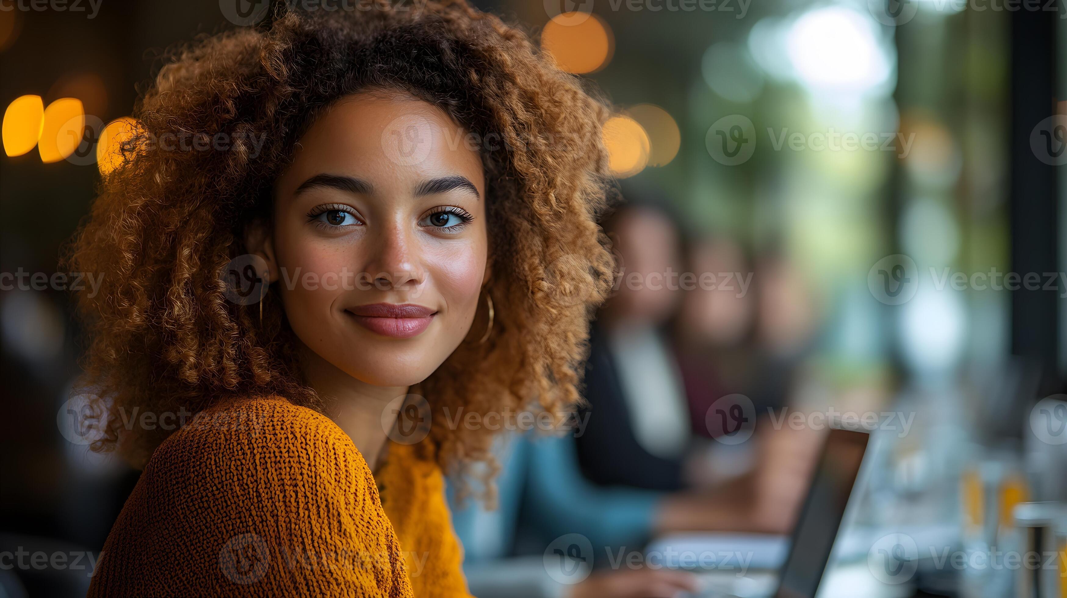 Marketing team discussing strategies around a large table with laptops and digital tablets ...