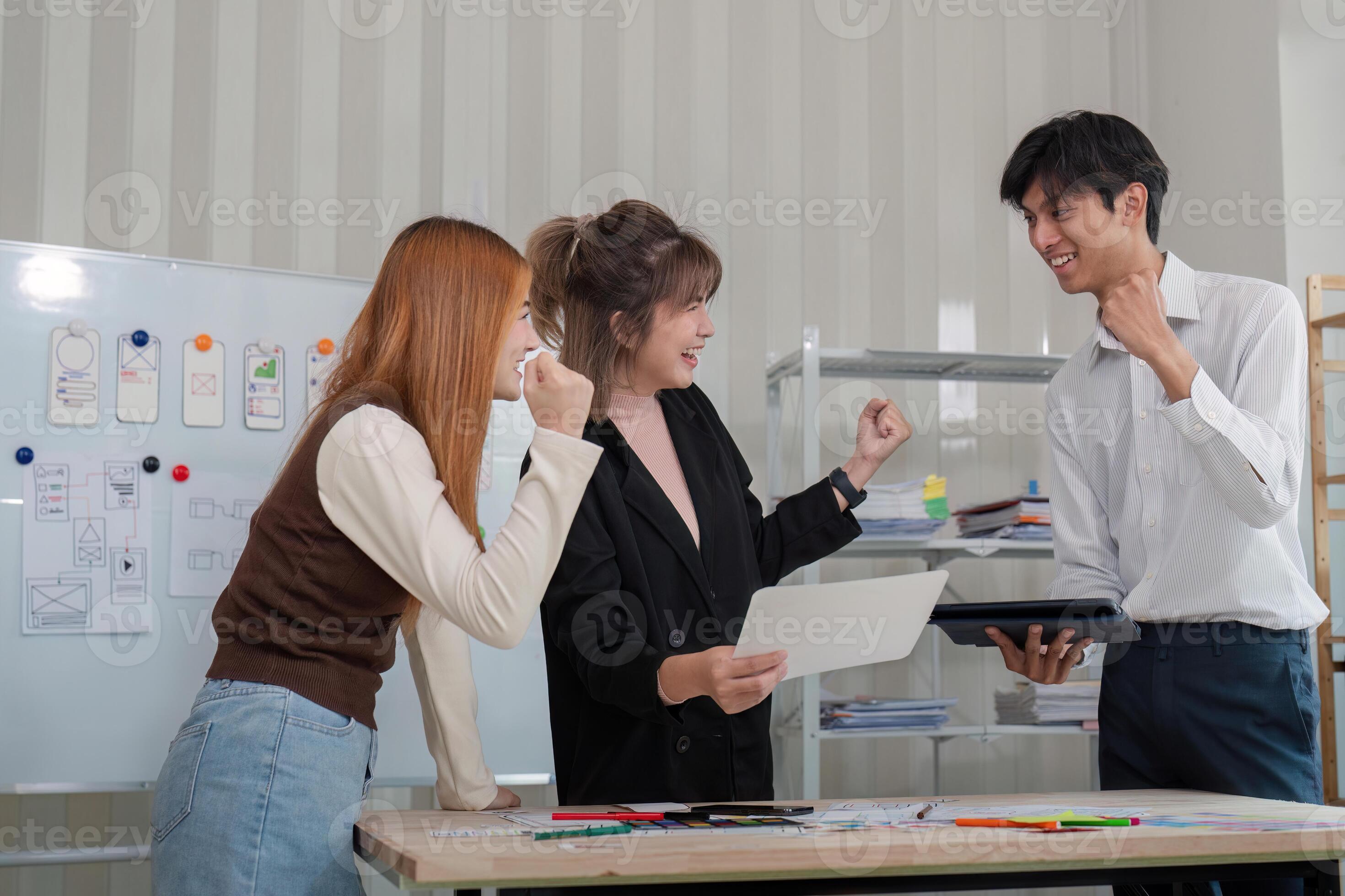 Energetic UX UI team celebrating successful design concepts during a collaborative meeting in a ...