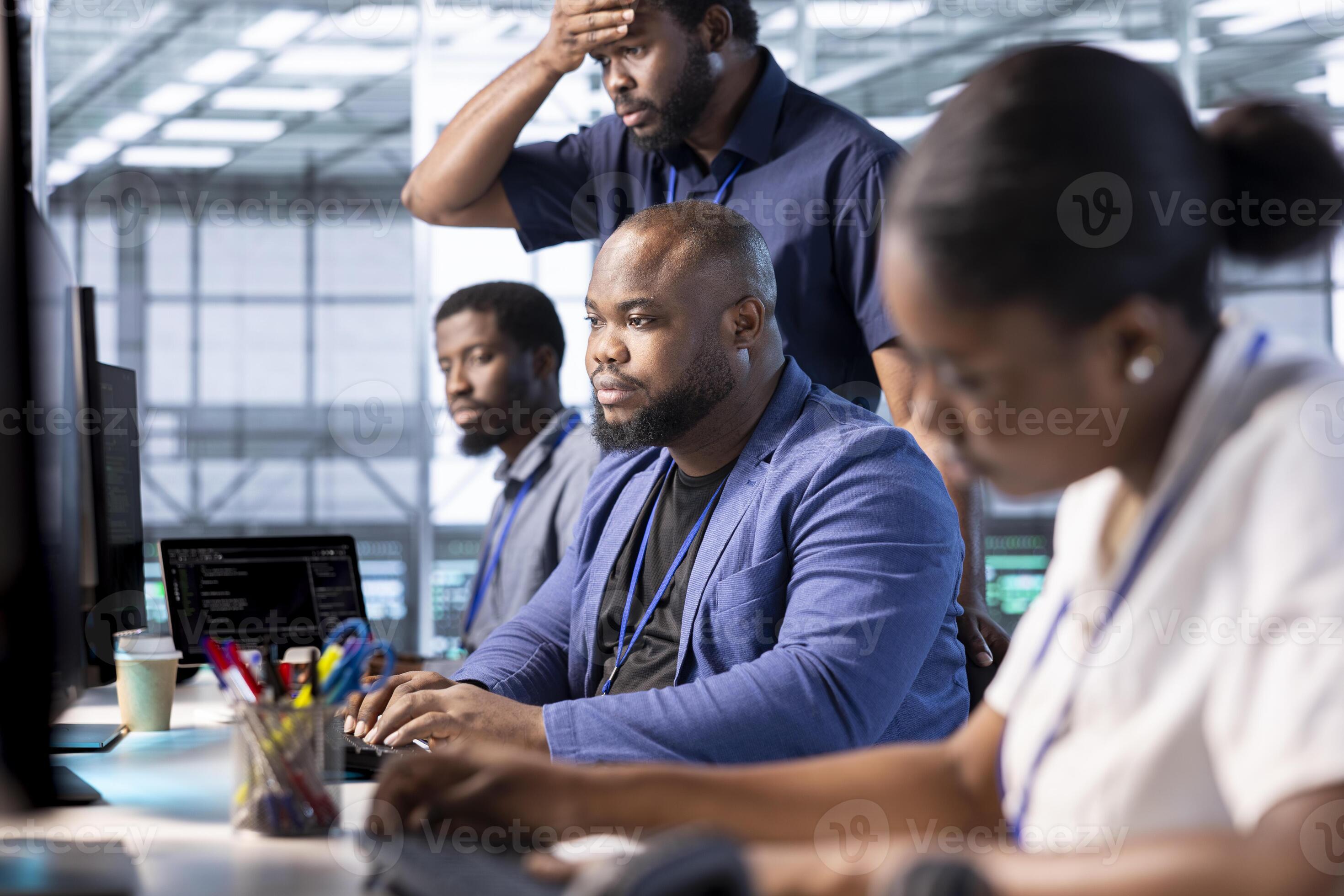 Group of programmers in data center using diagnostic tools and system monitoring software to ...