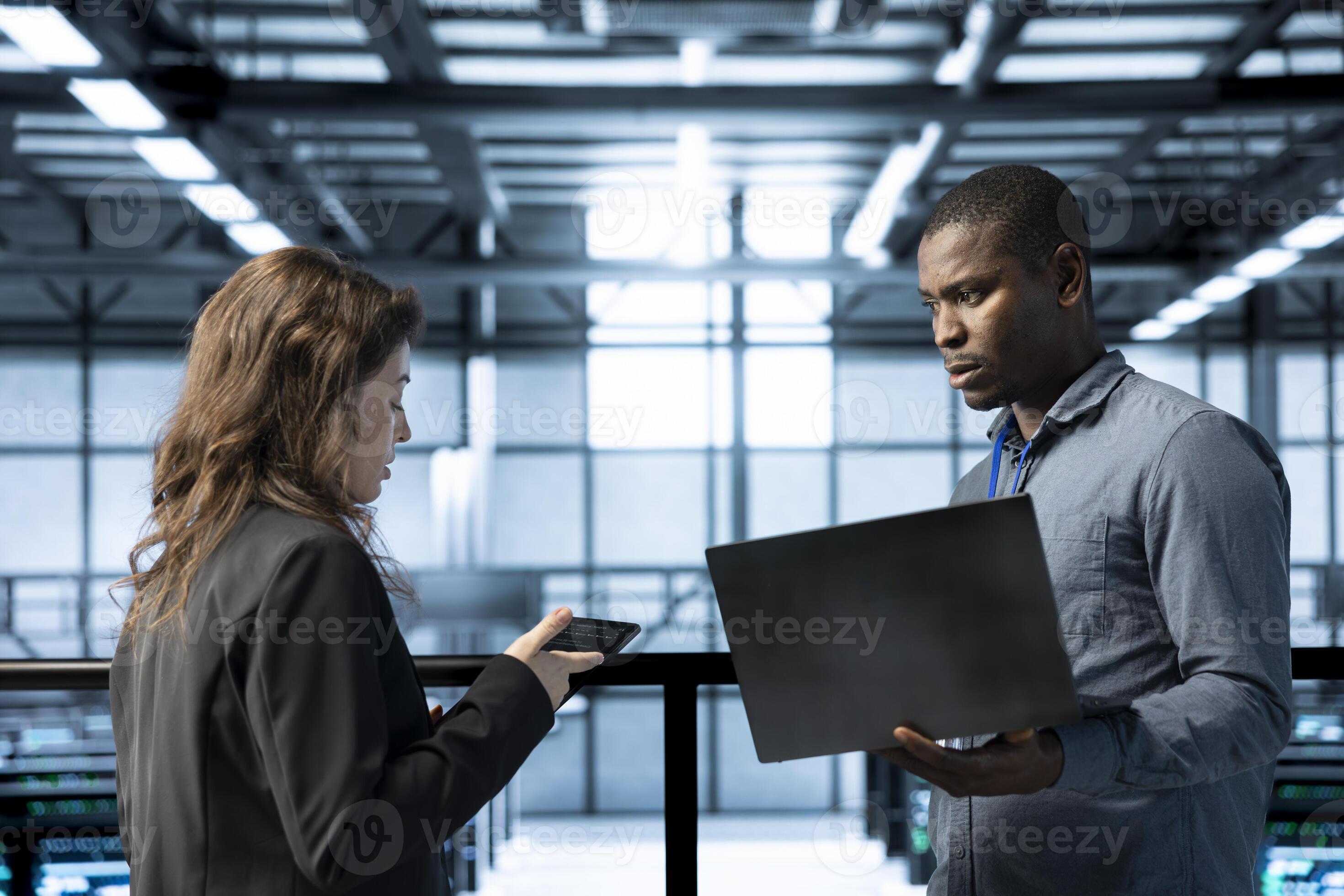Computer Scientists In Data Center Using Laptop And Tablet Executing