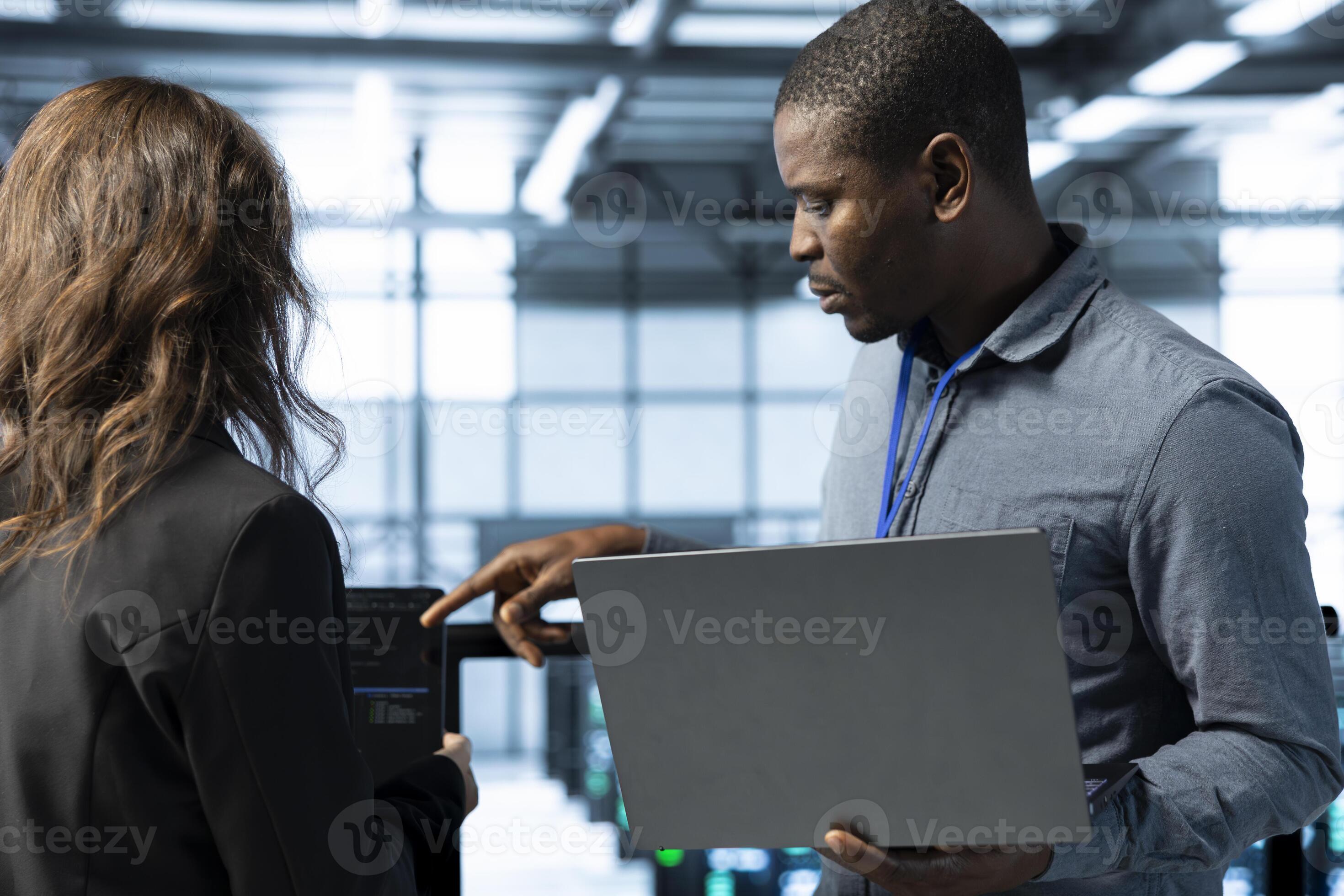 Colleagues In Data Center Workspace Use Laptop To Calibrate Energy