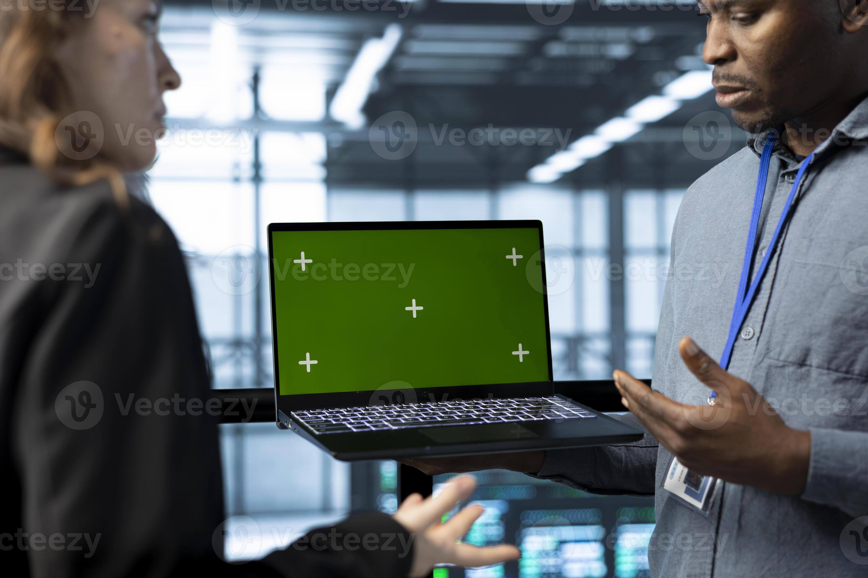 Teamworking coworkers in data center using automation tools on green screen mockup laptop ...