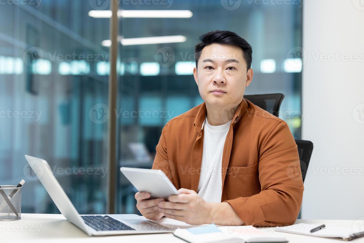Portrait of serious and concentrated man at workplace inside office ...