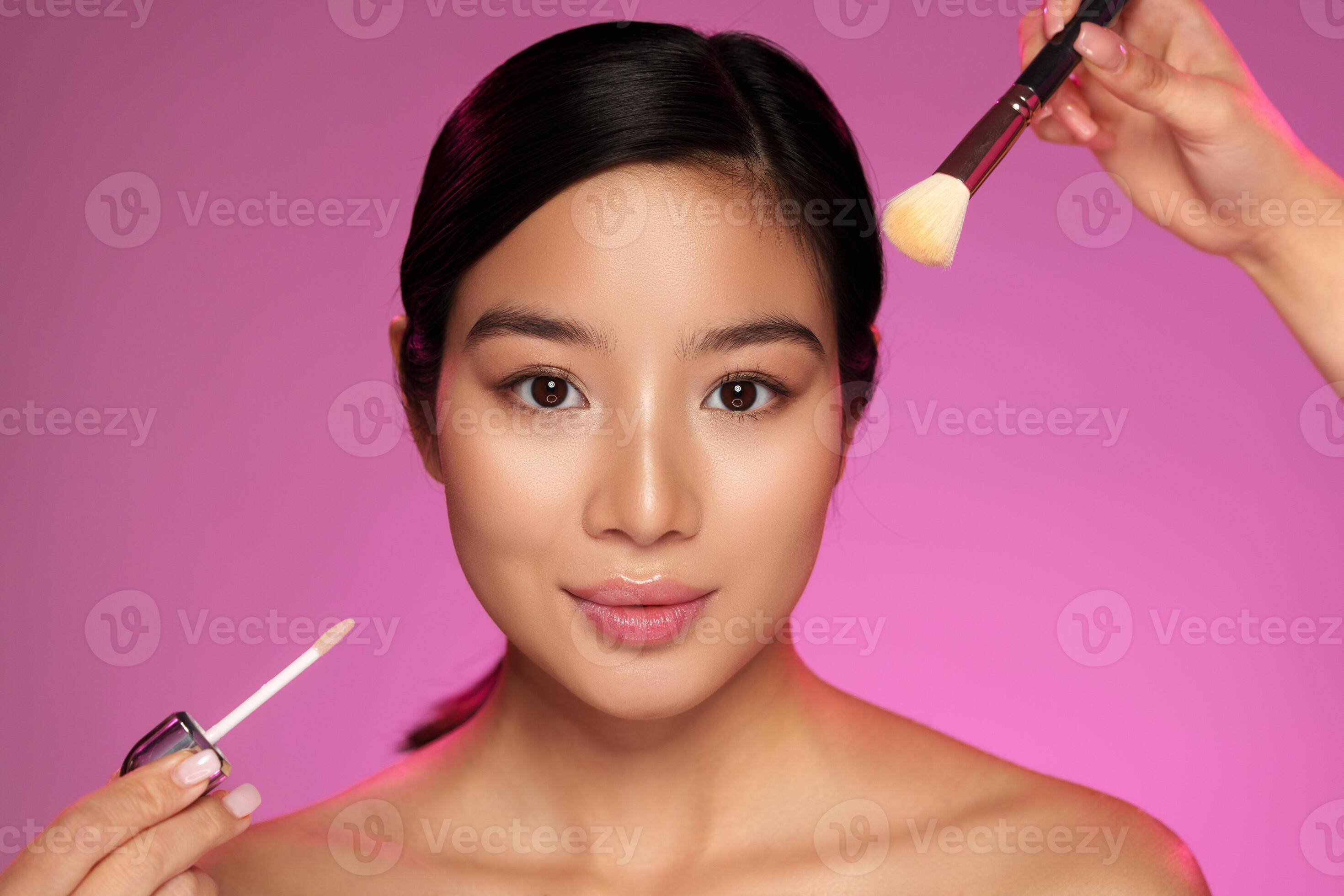 Makeup application on model with radiant skin and professional artistry in a studio setting ...