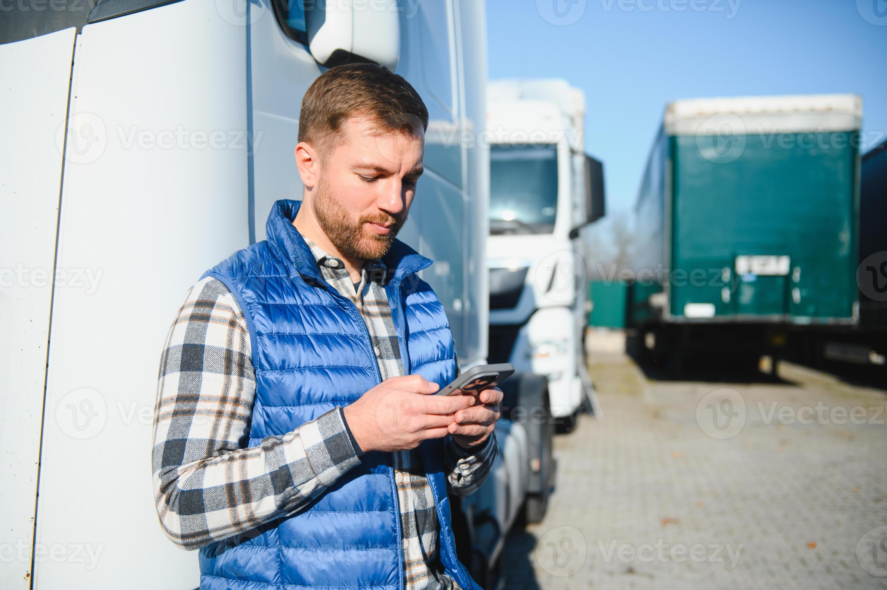 Professional driver using mobile phone while standing in front of his ...